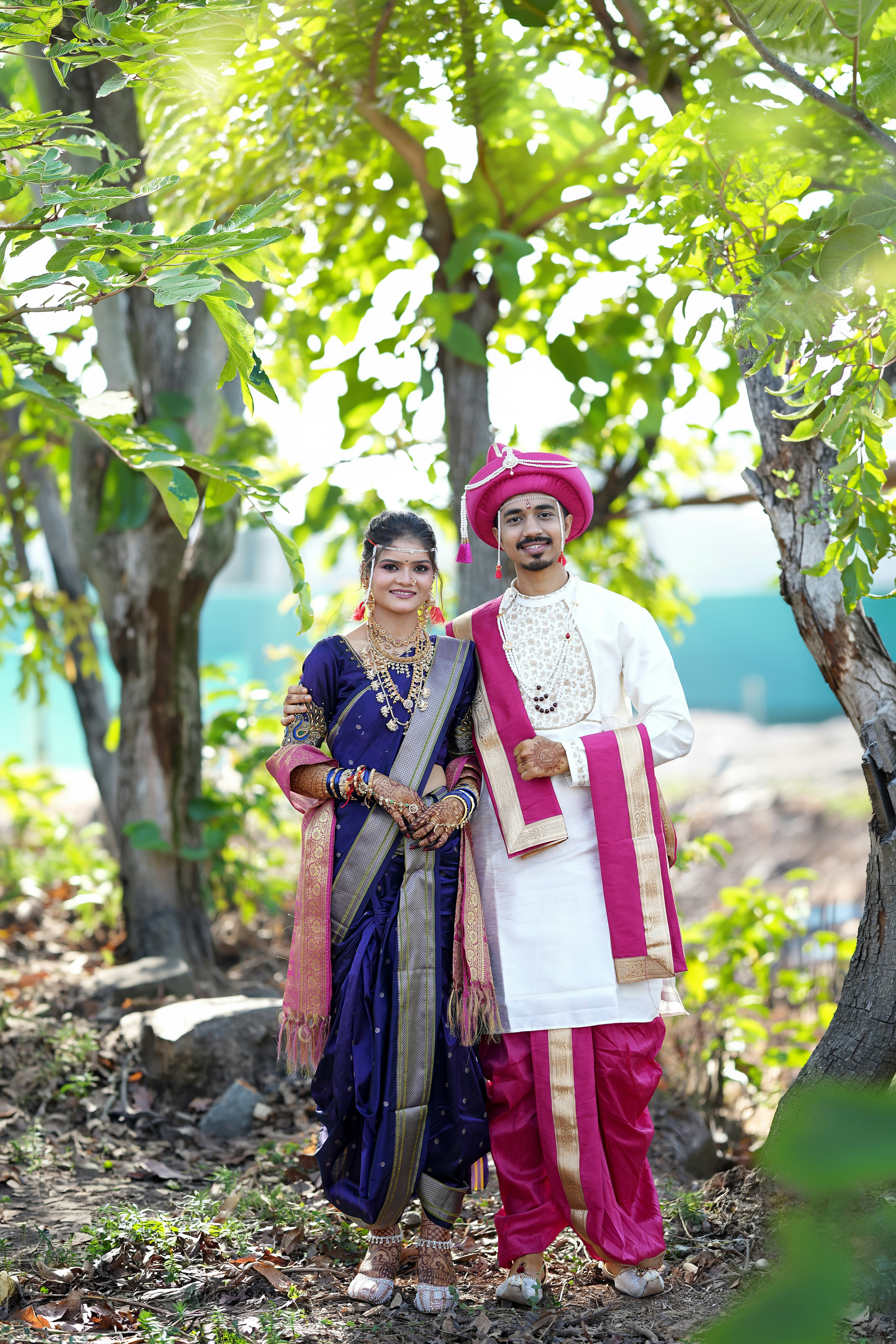 Bride and Groom in Garden Ritual, Vibrant Attire Amid Green Canopy