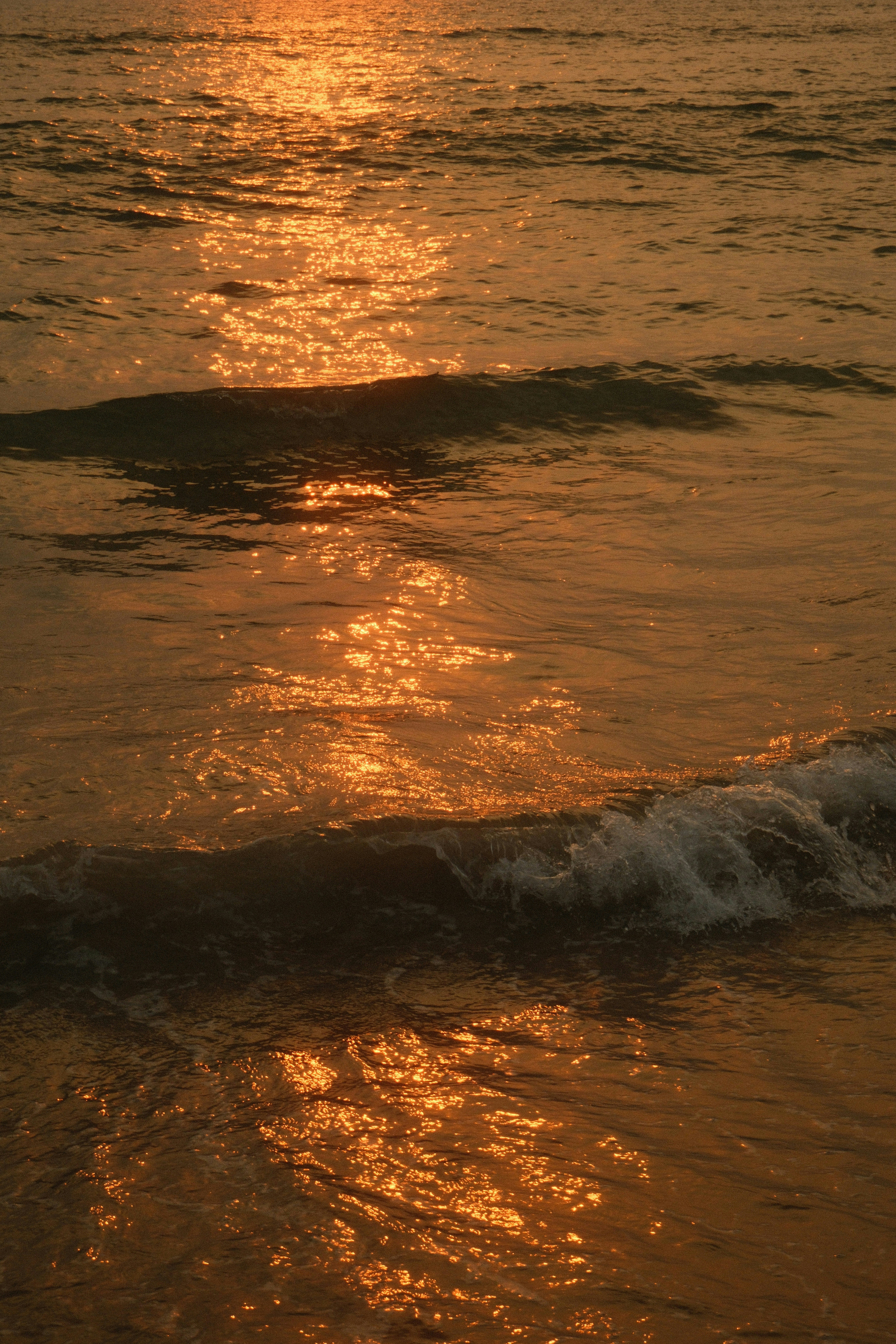 Glow on the Crest: Sunset Reflections on Quiet Waves