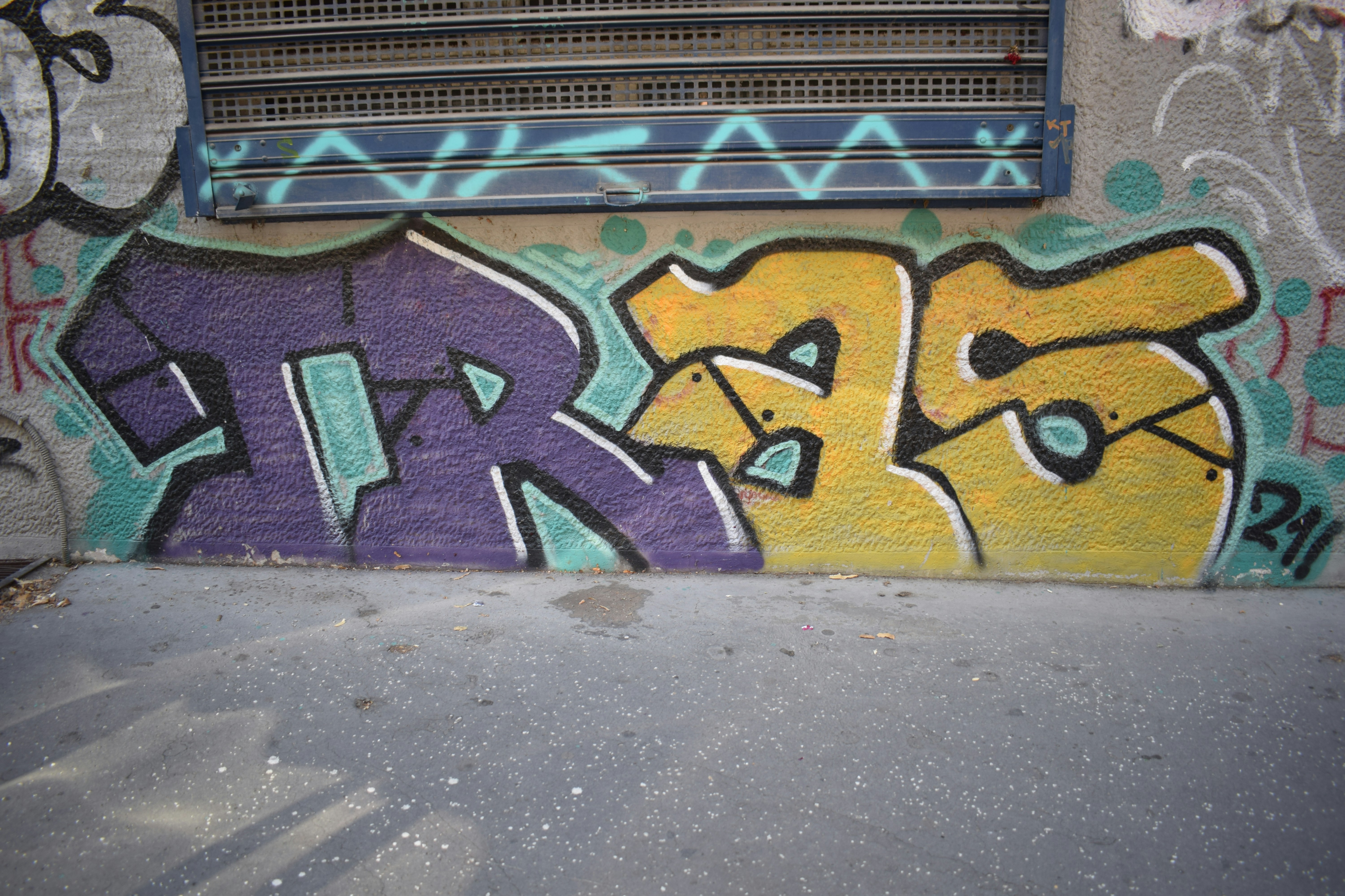 Graffiti Bloom: Bright Yellow Letters Framing a Shuttered Wall