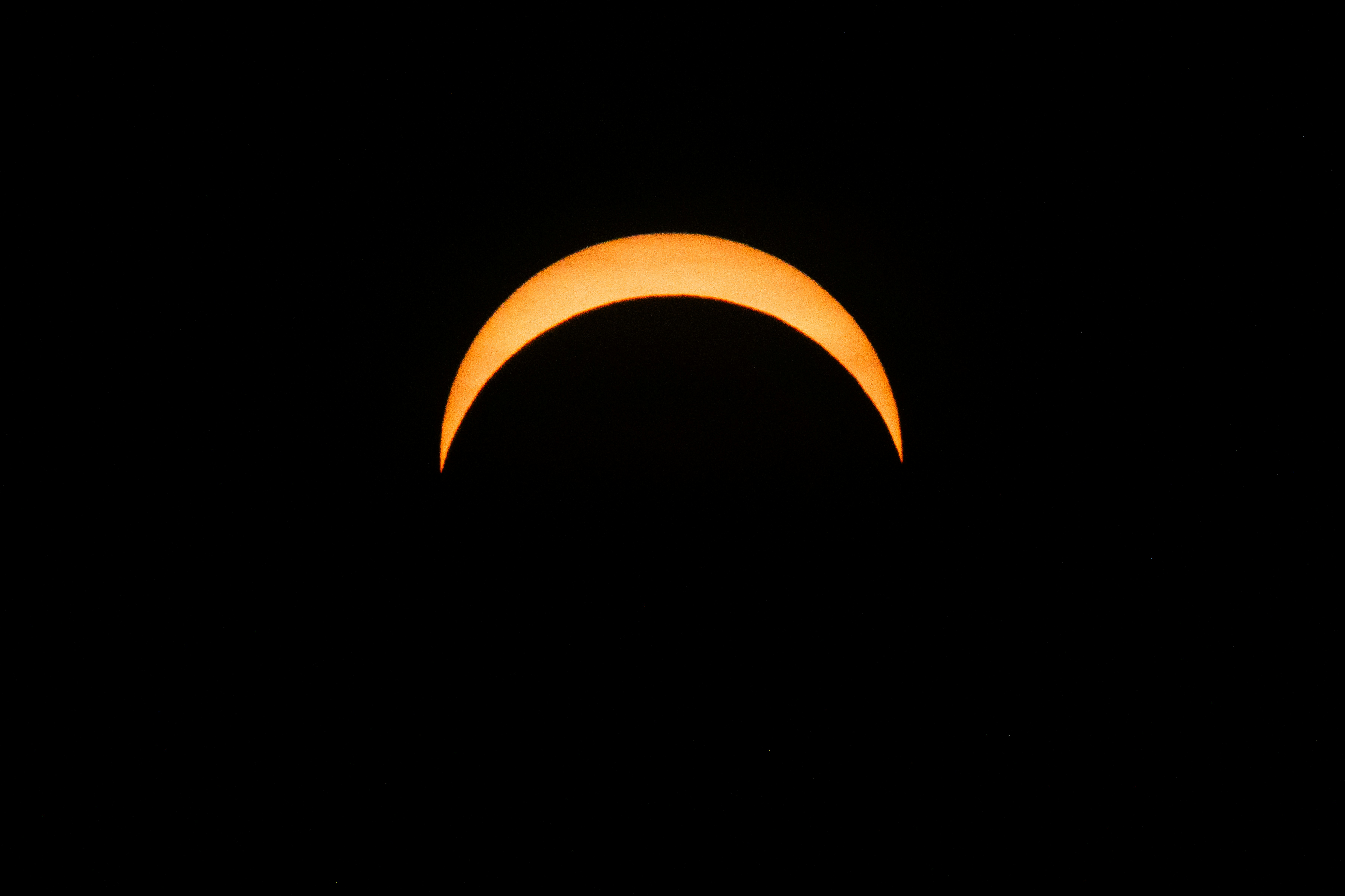 Luminous Crescent: Solar Eclipse Halo Against Night