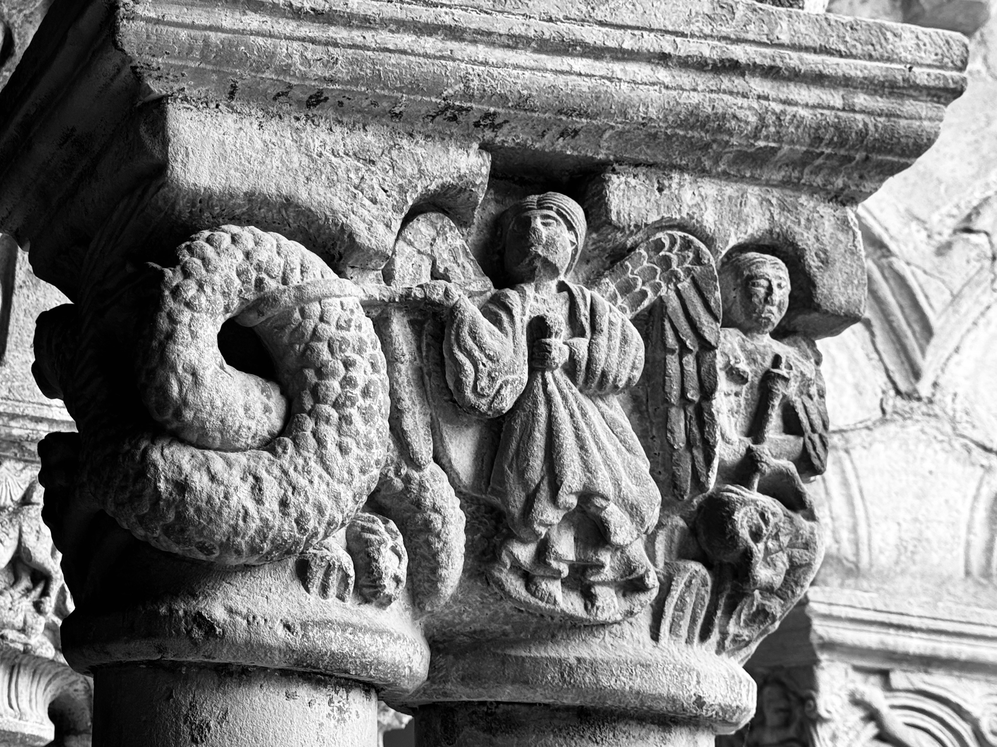 Carved angelic figure under stone archway: a grayscale detail of architectural sculpture