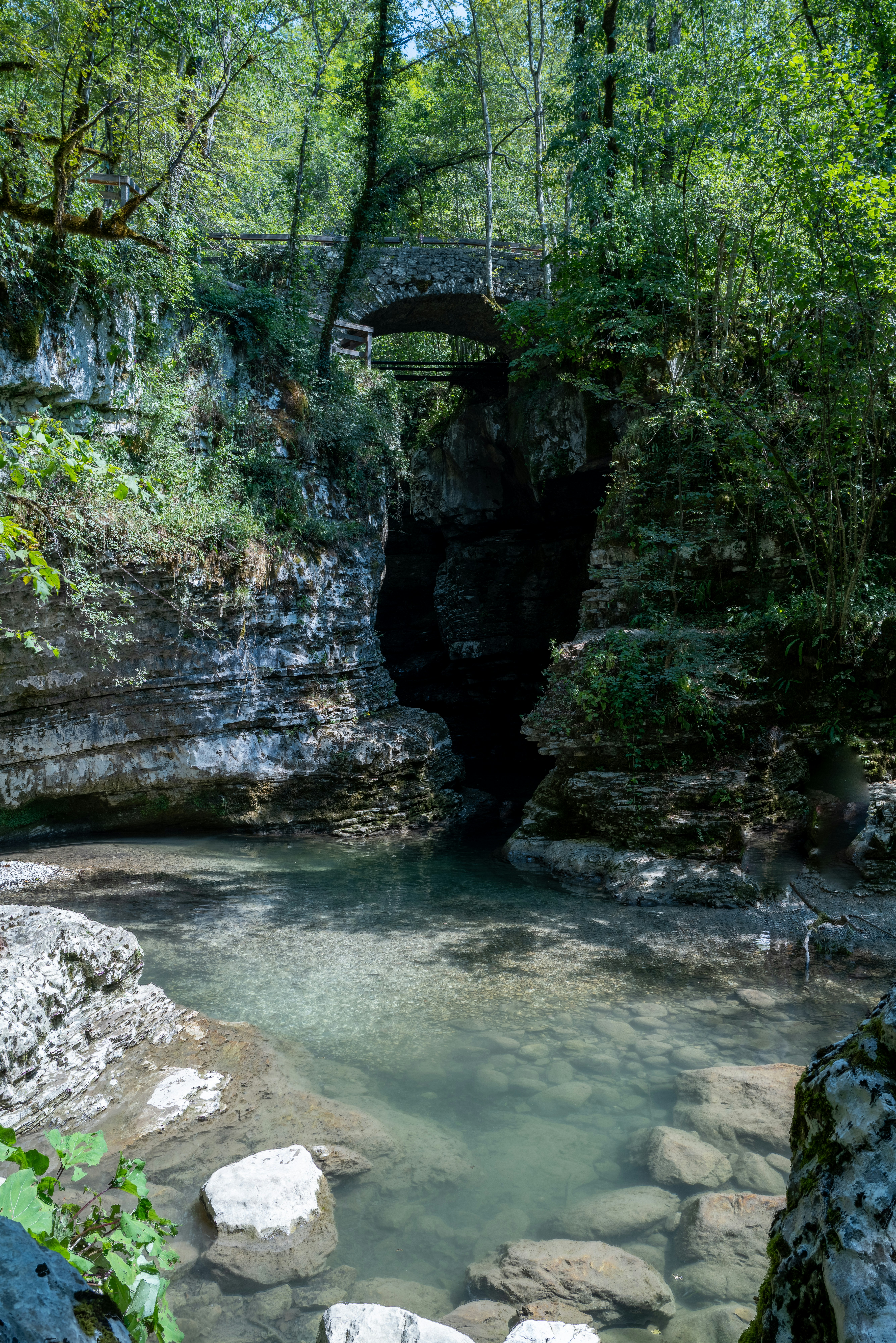 Stone Bridge Over Quiet Aqua: A Sunlit Gorge Awakens