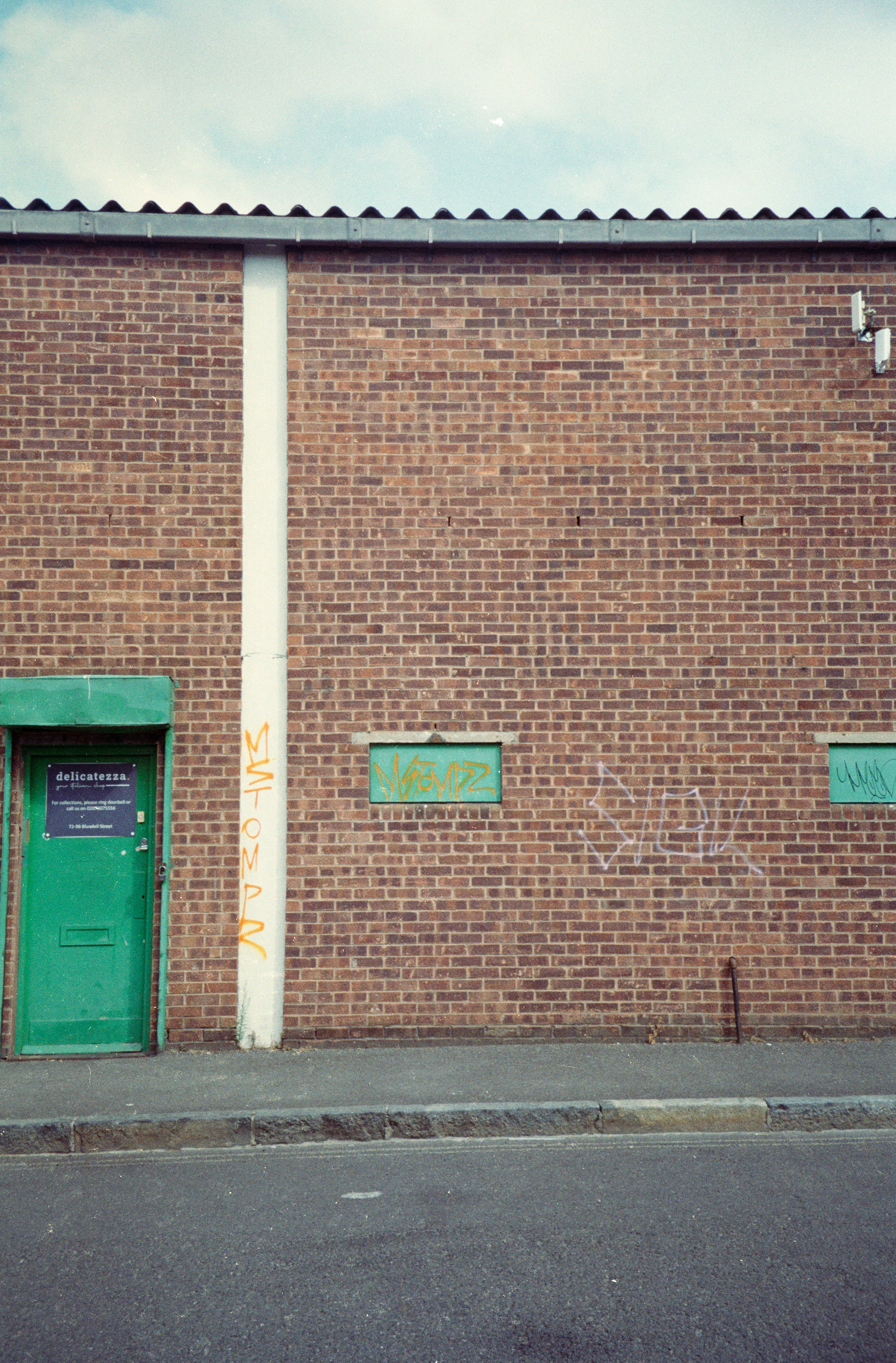 Green Door on a Graffiti-Streaked Brick Wall