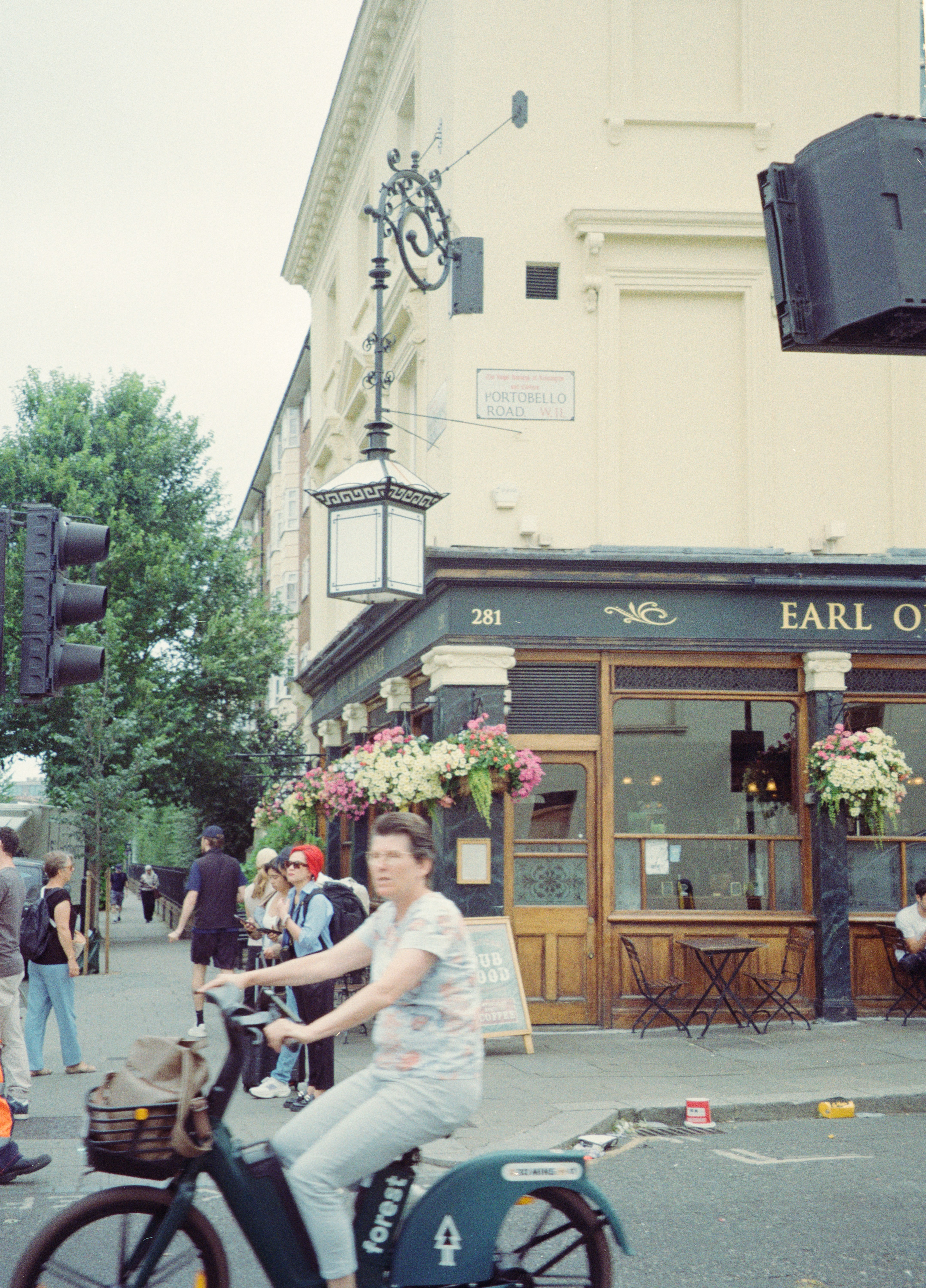 Cyclist in the foreground pass by Earl of ... on a sunny London street