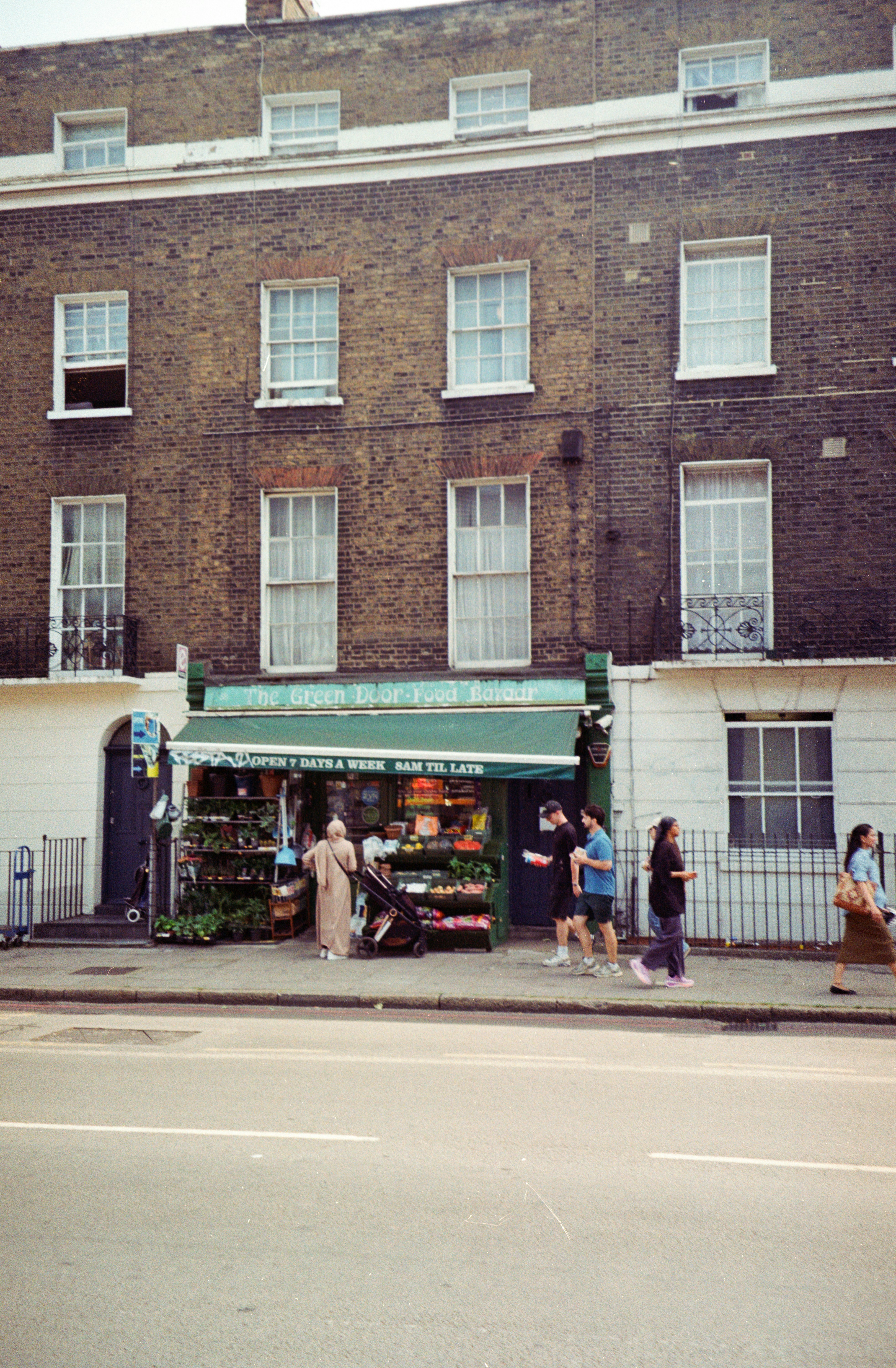 Brick Facade and Green Market Awning: Urban Life in Bloom