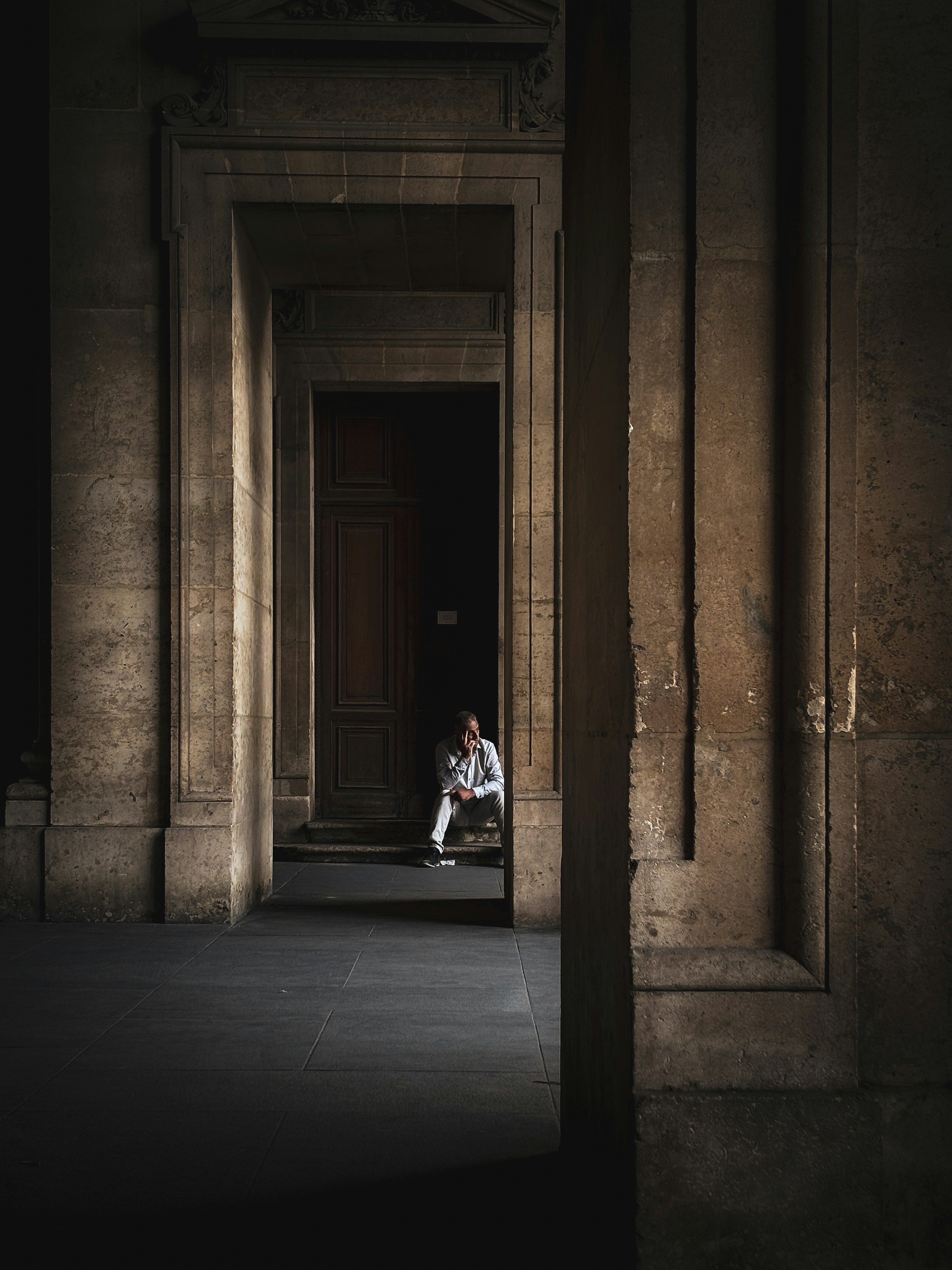 Waiting in the Doorframe: A Quiet Figure Amid Stone Echoes