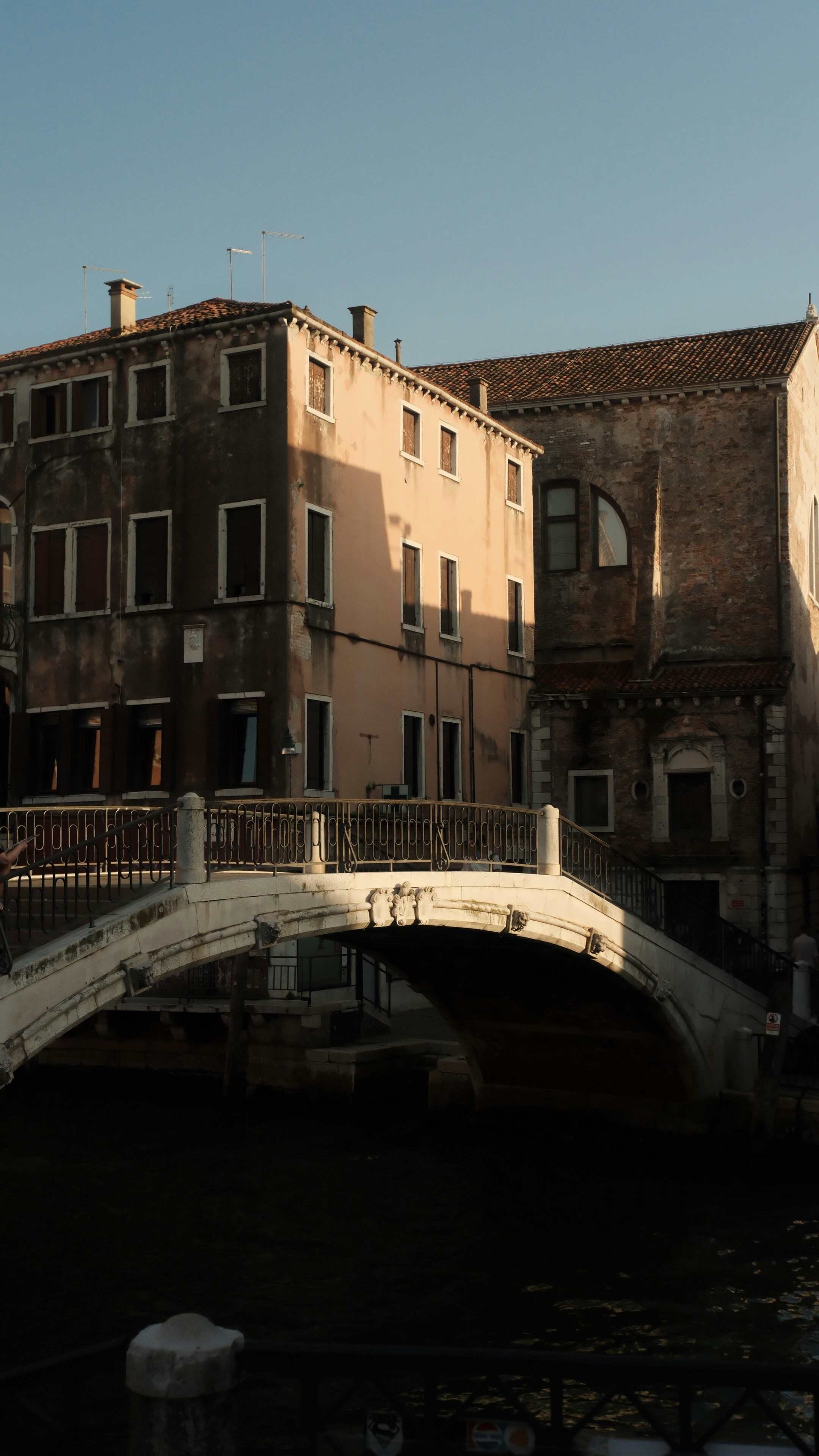 Sunlit Facades and a Quiet Canal: Venice Through a Bridge**,