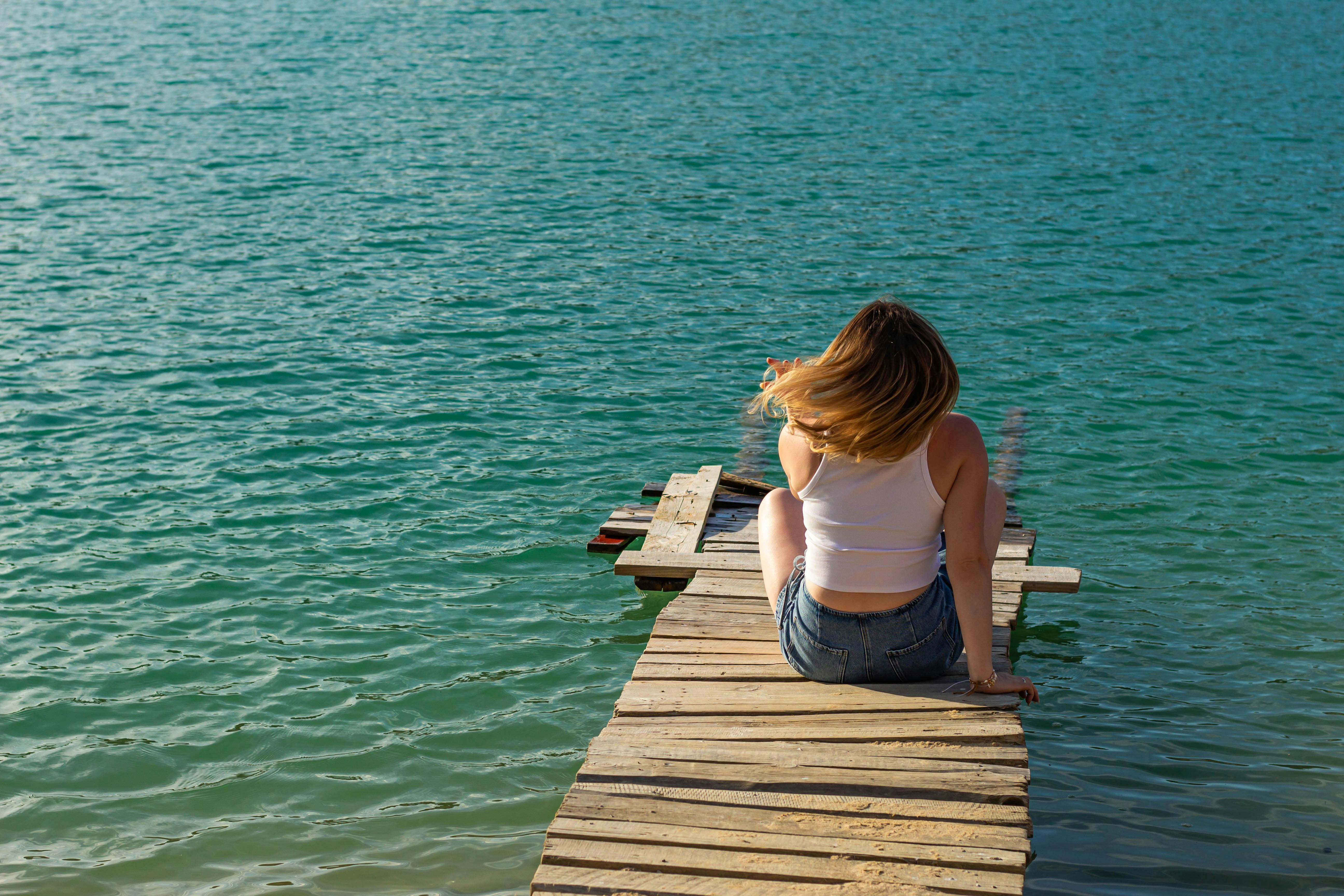 Woman on a Weathered Dock Reaches for the Horizon