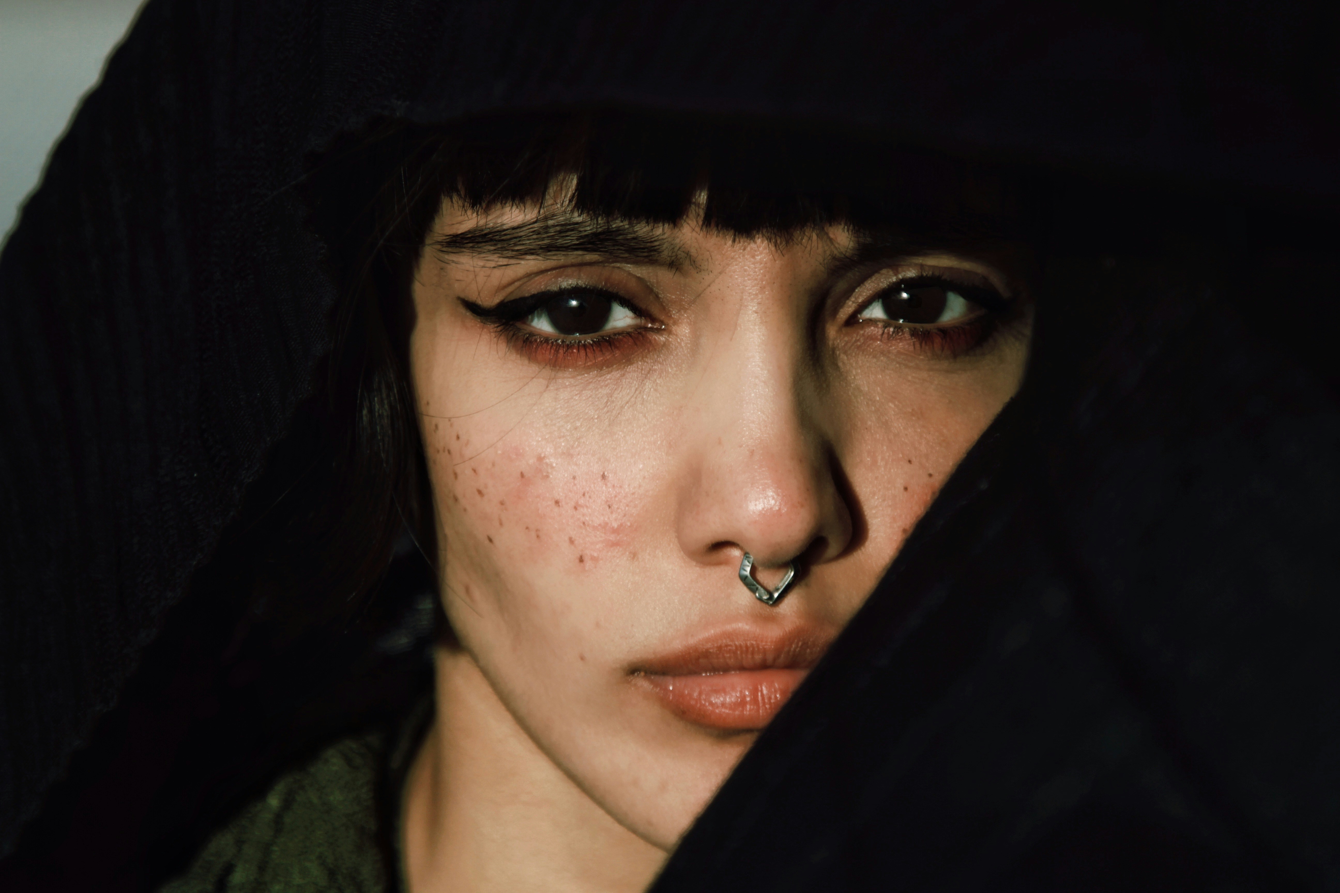 Veiled Gaze: A Close Portrait in Shadowed Fabrics