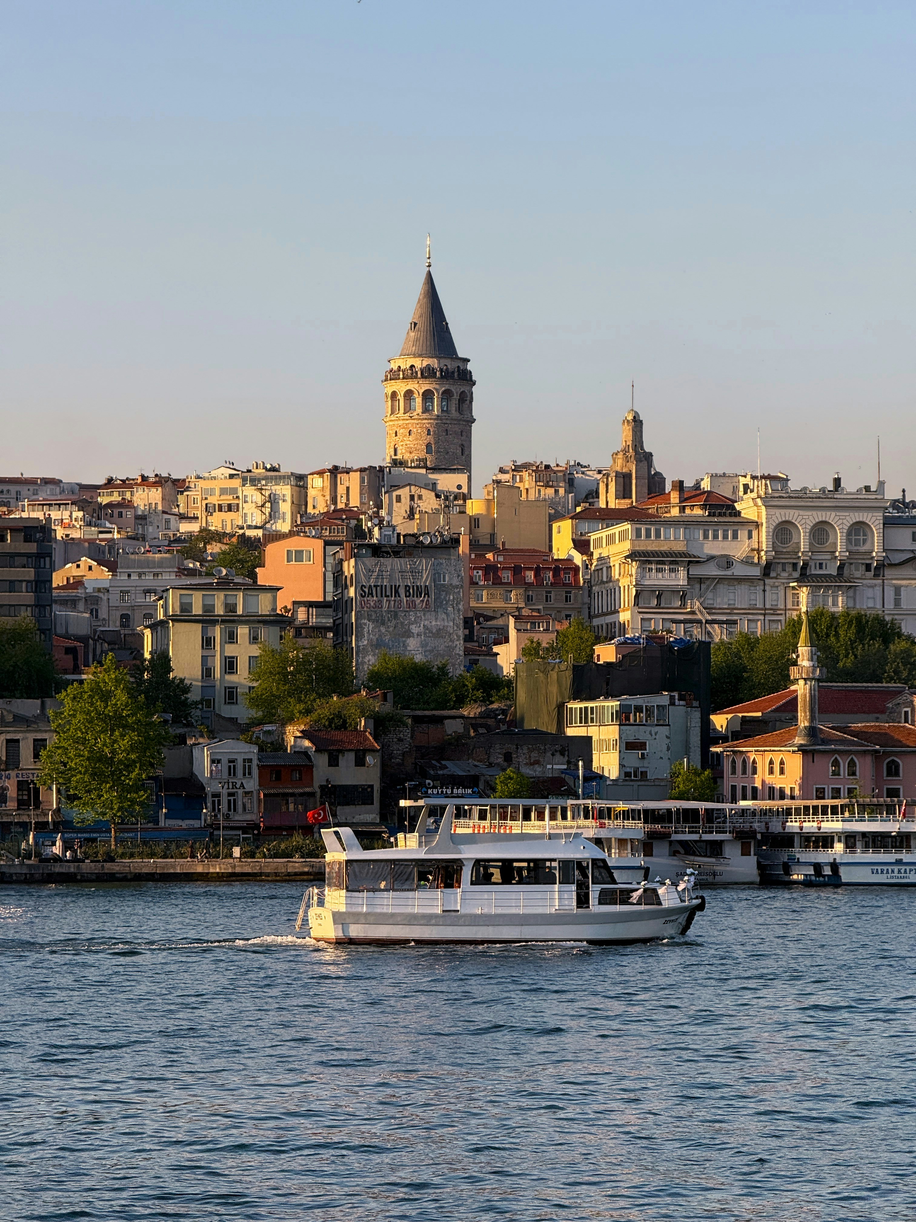 Bell-tower silhouette over a sunlit harbor village