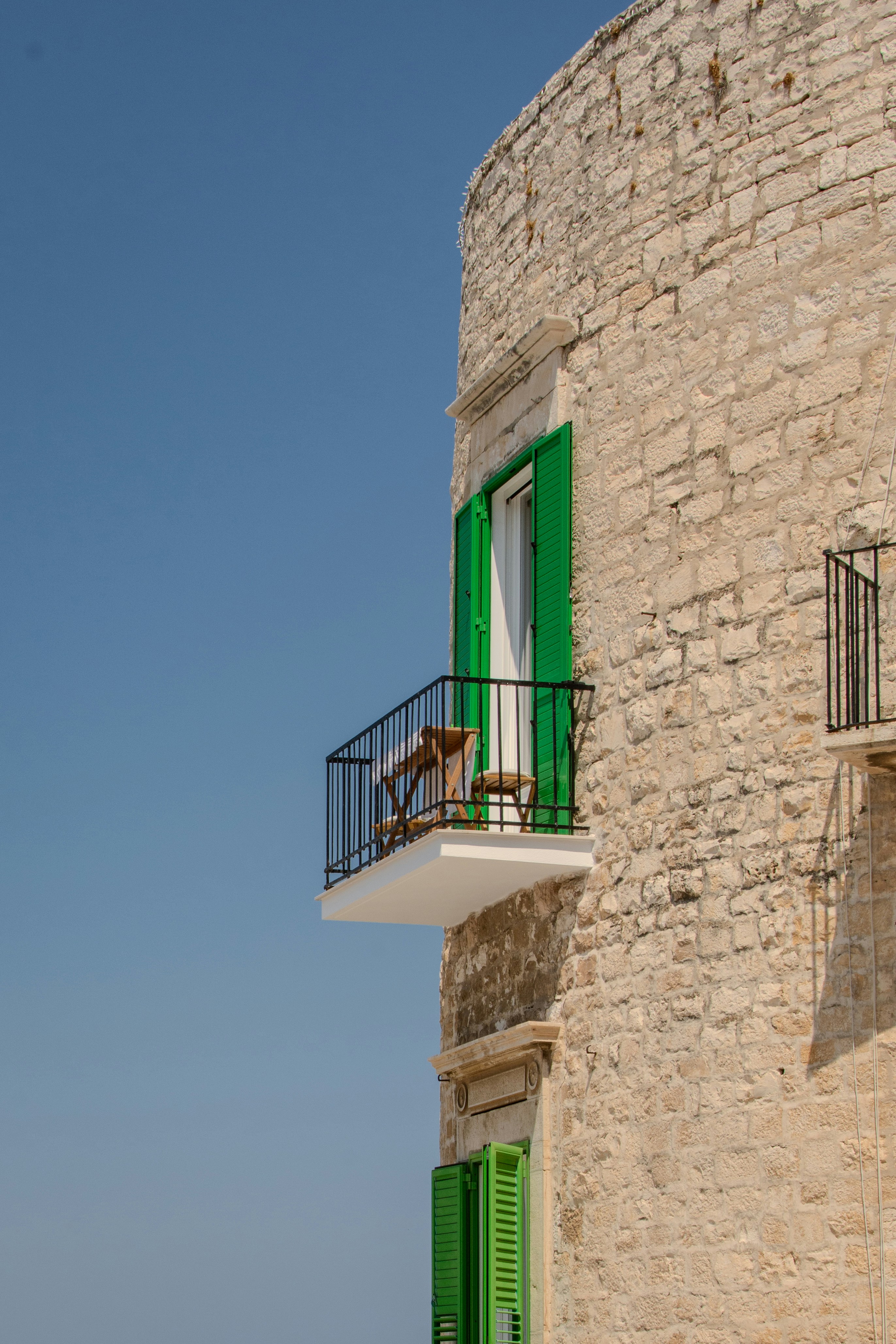 Green Door Balcony Overlooking Calm Blue Sky