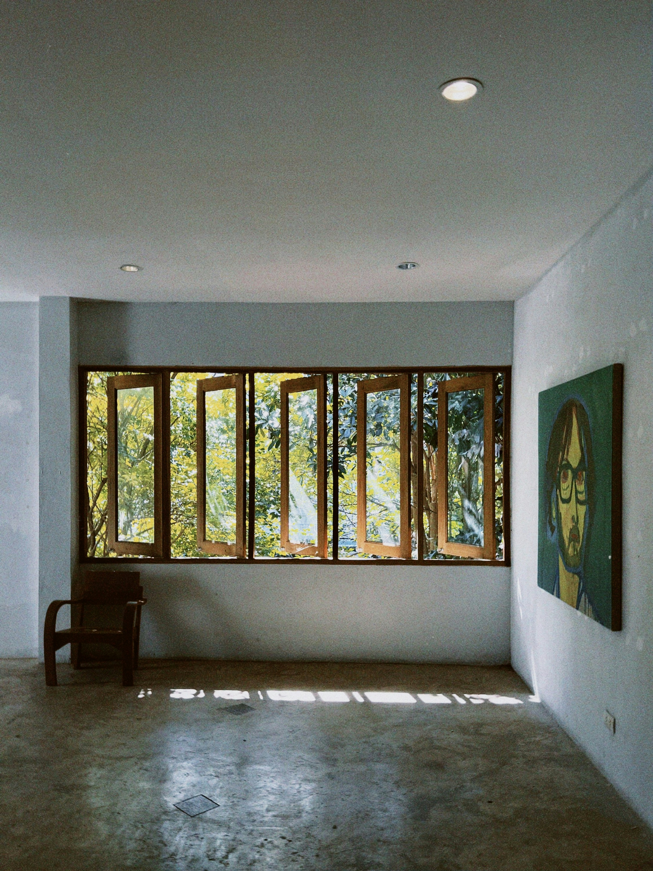 Sunlit Gallery: Windows, Chair, and Portrait in a Quiet Room