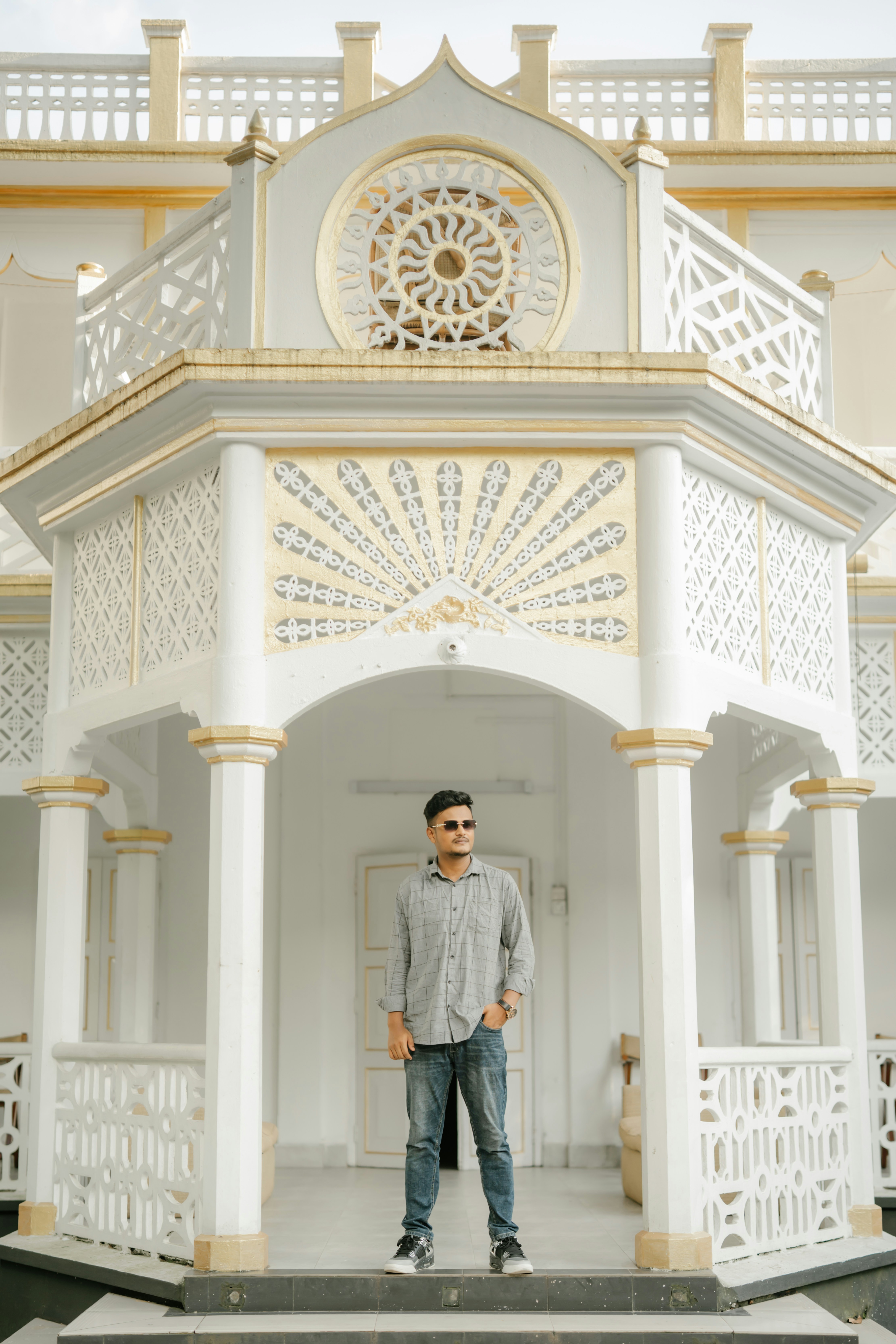 Portrait beneath ornate arches: a calm presence in an ivory pavilion
