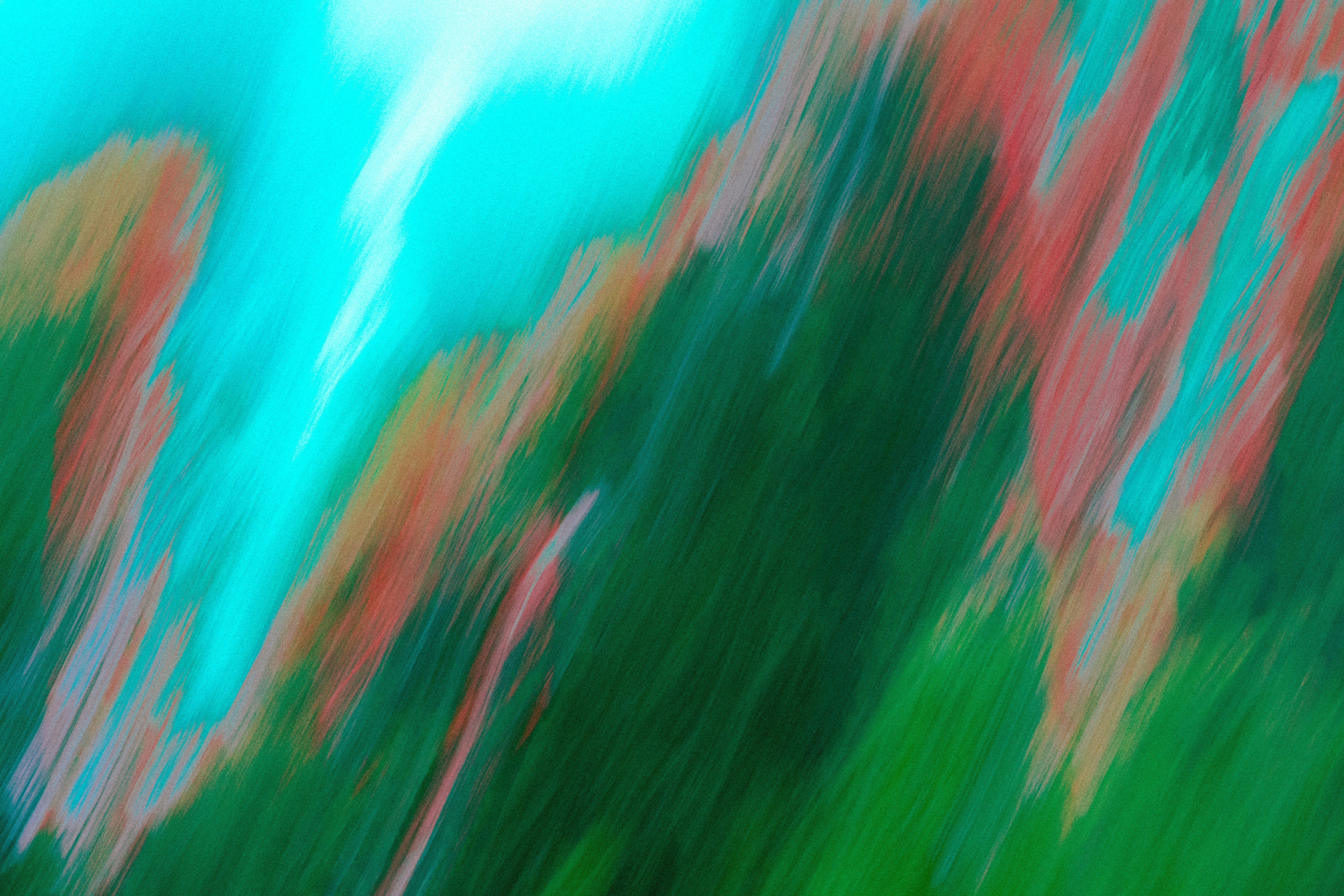 Abstract motion blur with diagonal streaks of green, red, and bright cyan