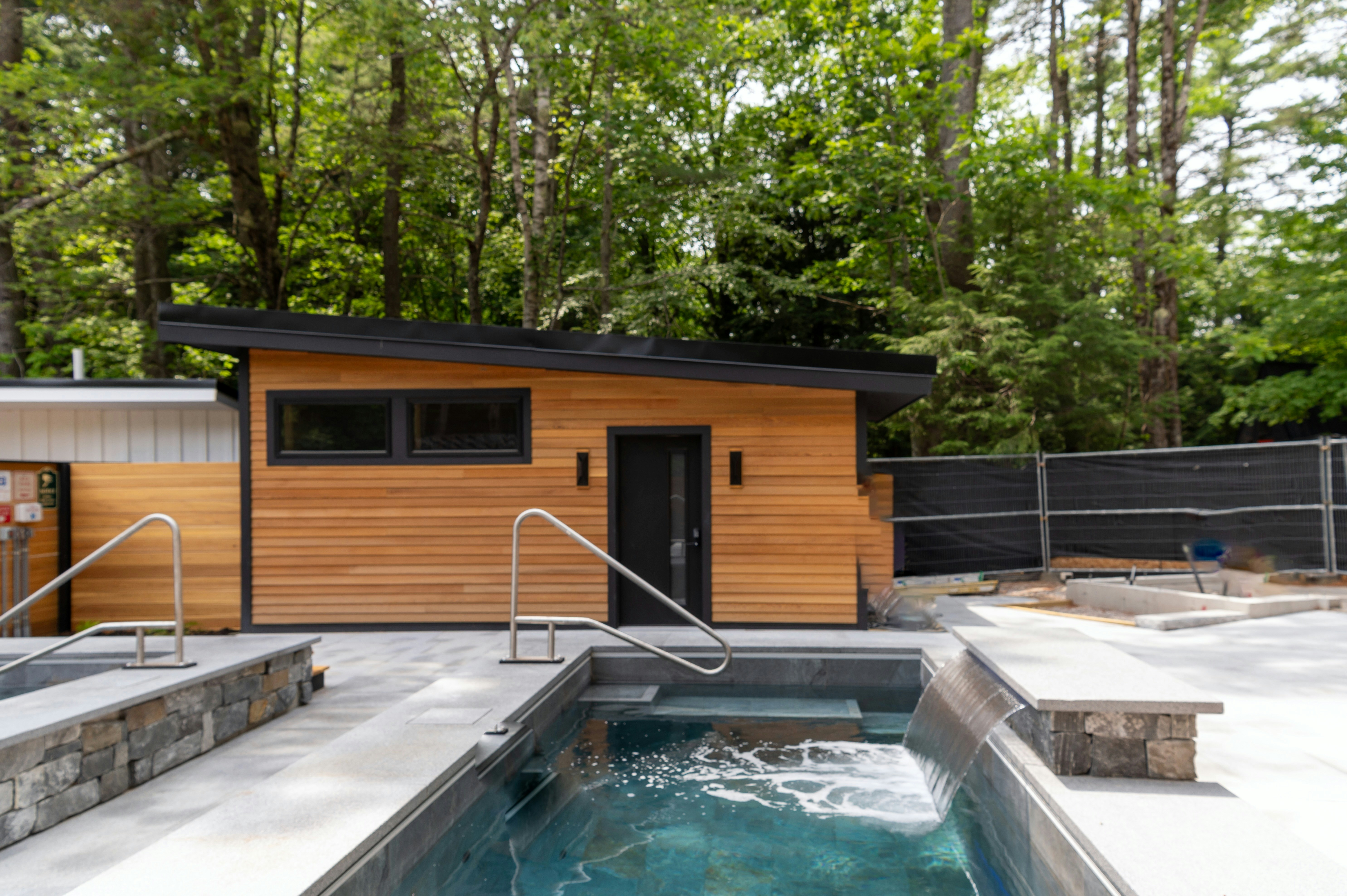 Cottage-style poolside retreat with a sleek wooden cabana