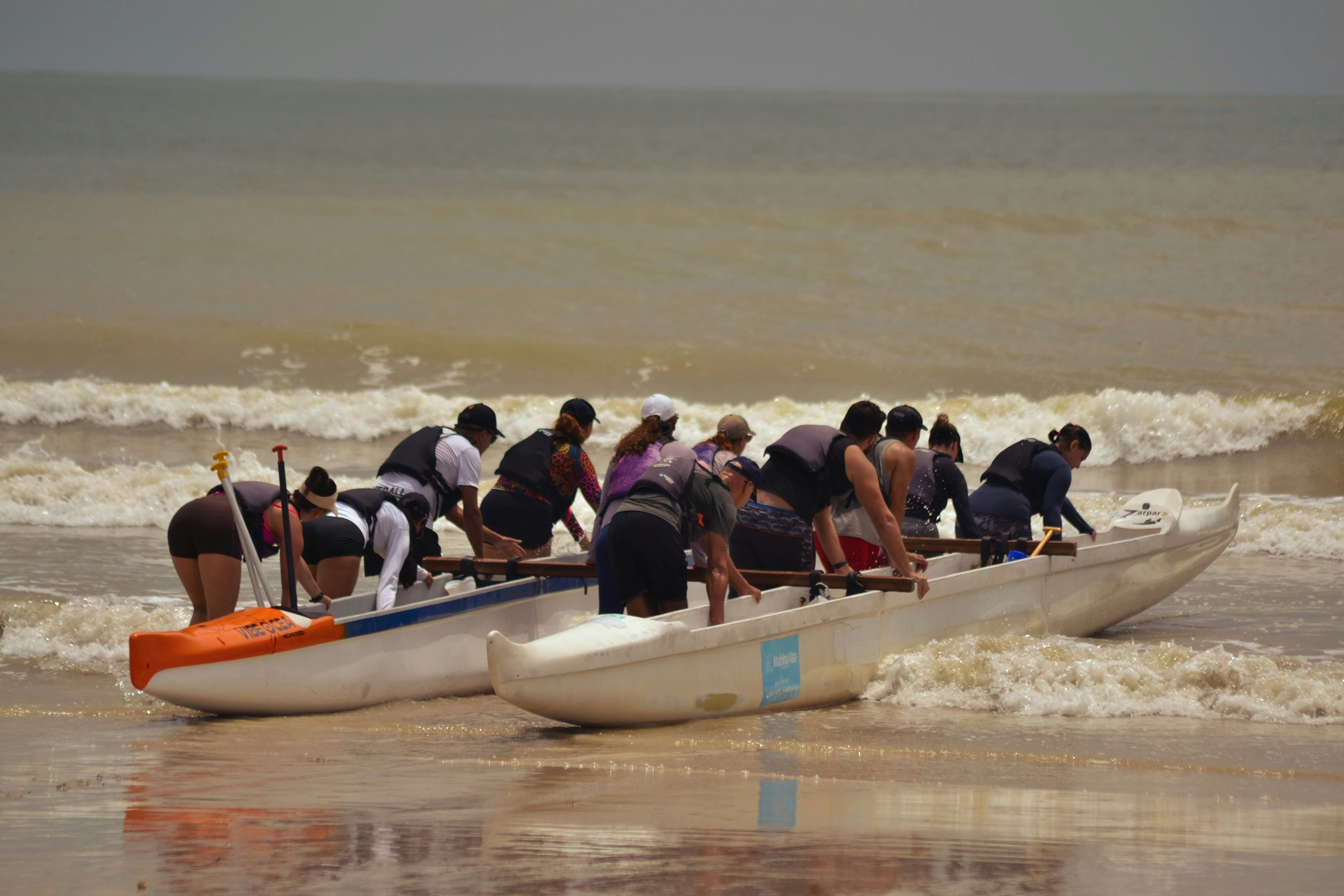 Team Effort: Rowers Ready the Canoe on a Sea-Burnished Shore