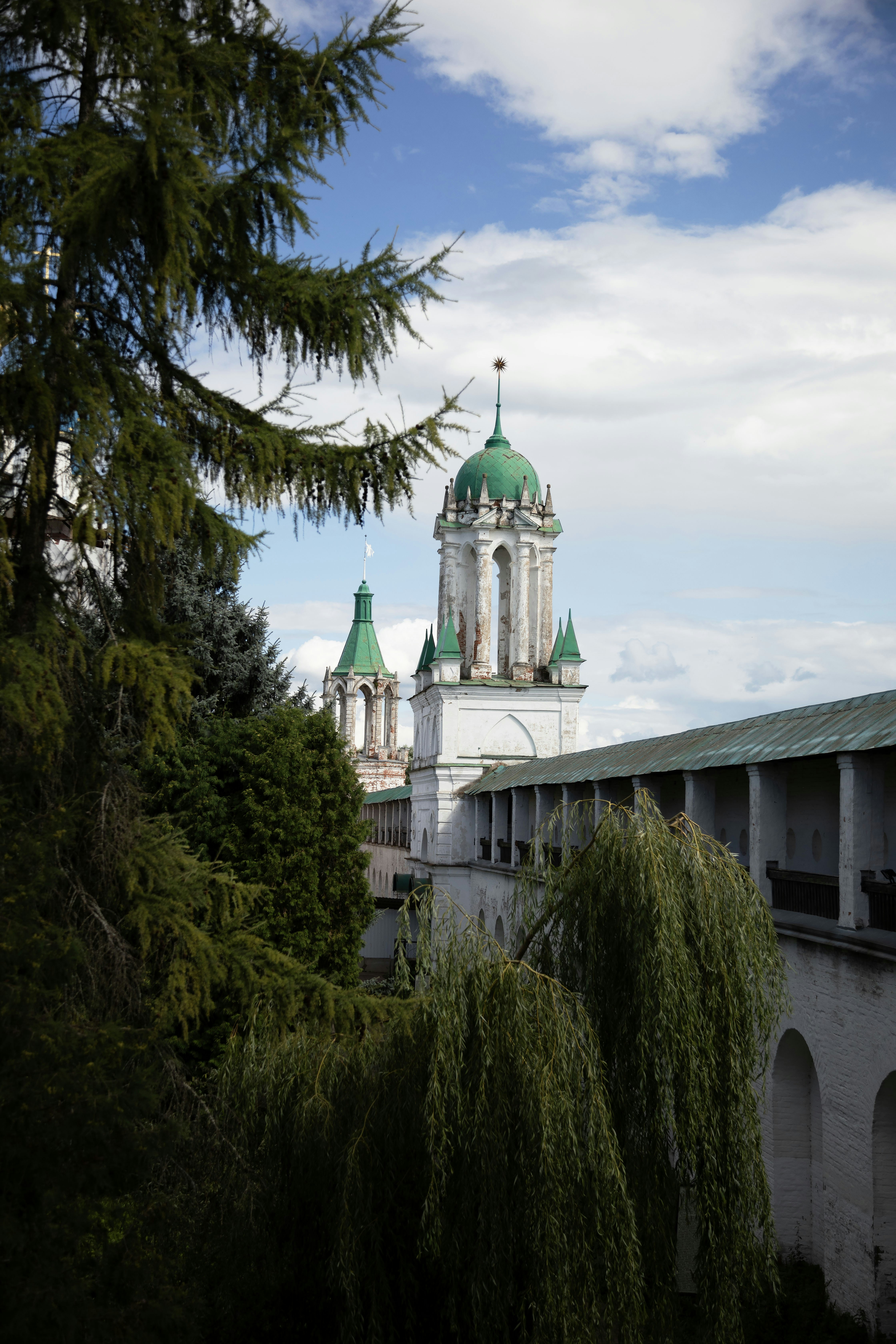Green-domed towers over a serene cloistered walkway