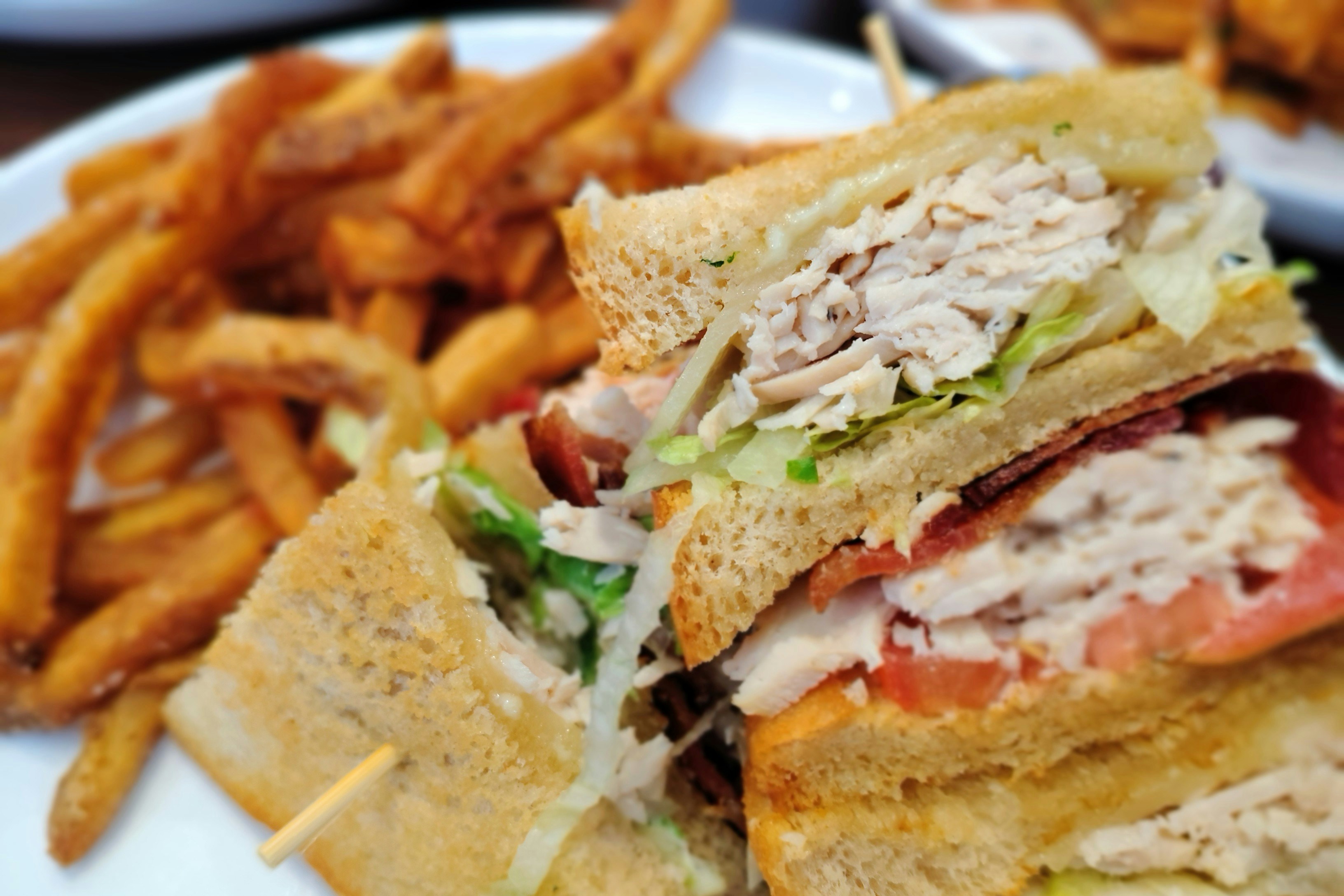 Triple-Layer Club on a Plate: Juicy Chicken, Crisp Bread, and Golden Fries
