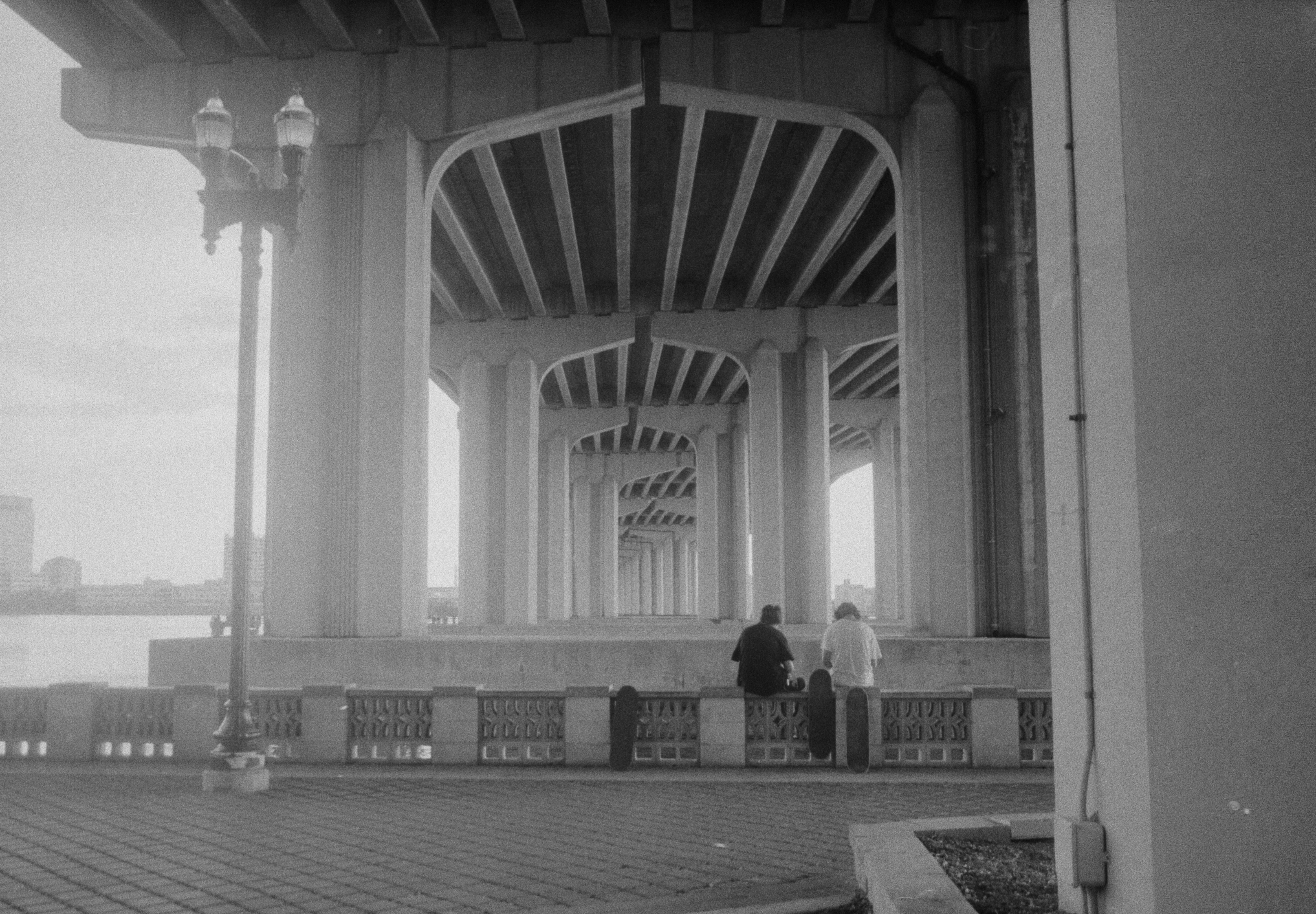 Under the Pier: Quiet Figures and Repeated Arches