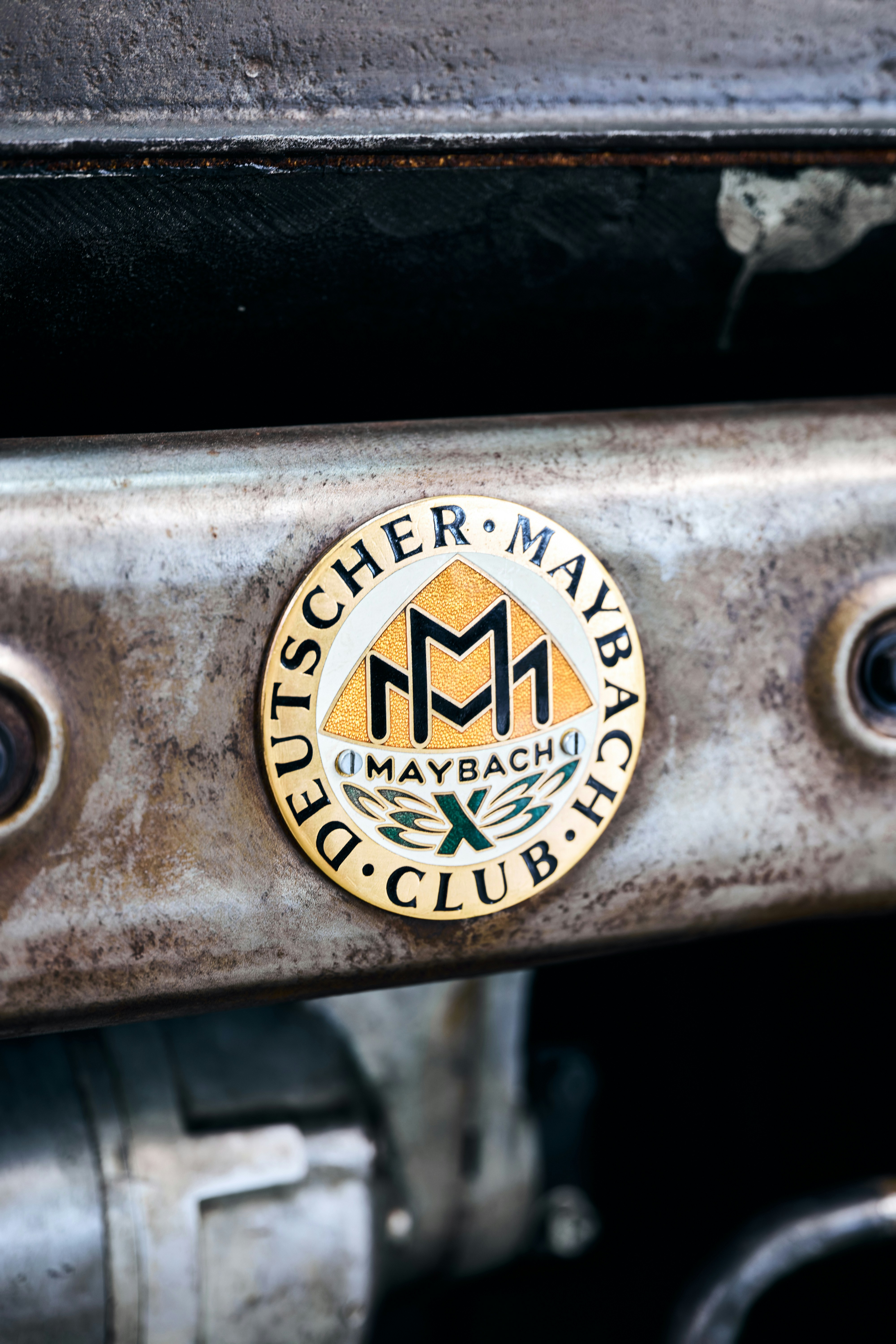 Emblem on Weathered Engine Plate: Maybach Crest Embedded in Rust