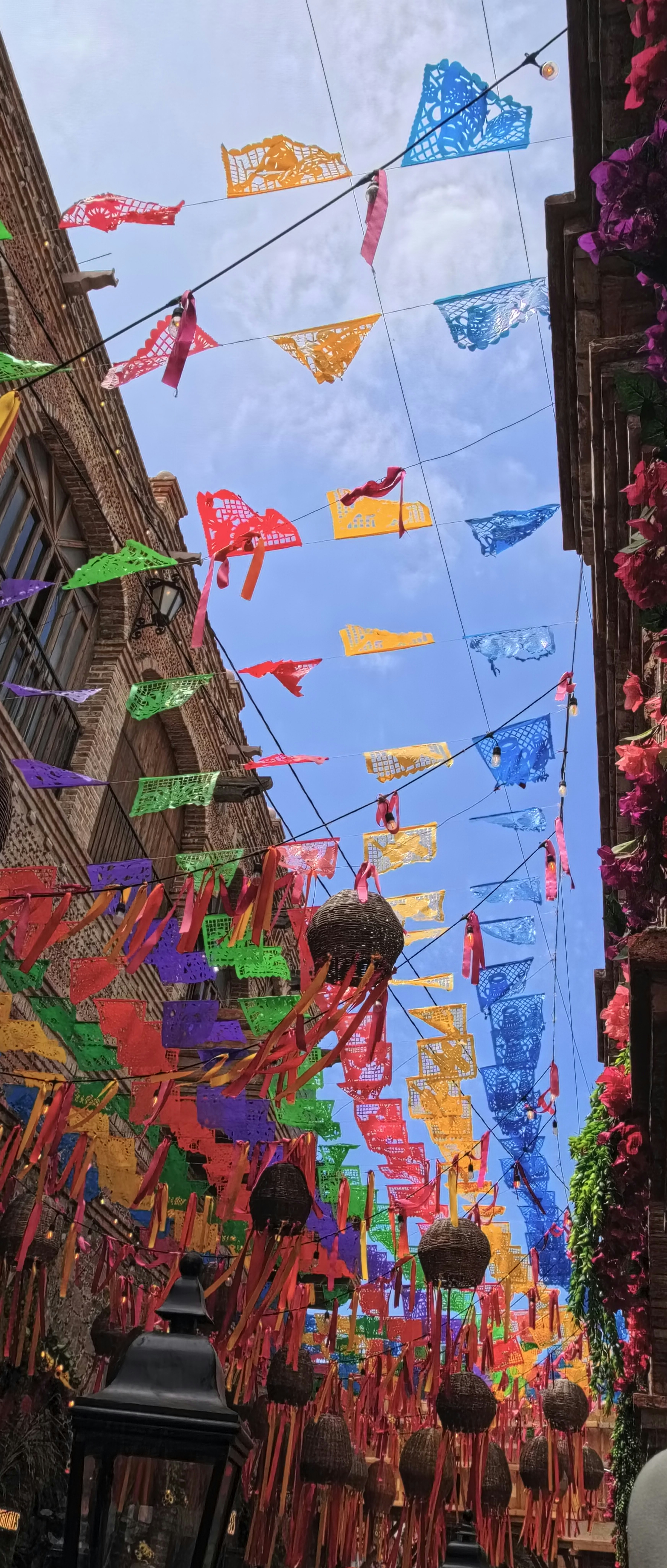 Colorful Paper Flags Over a Narrow Calle