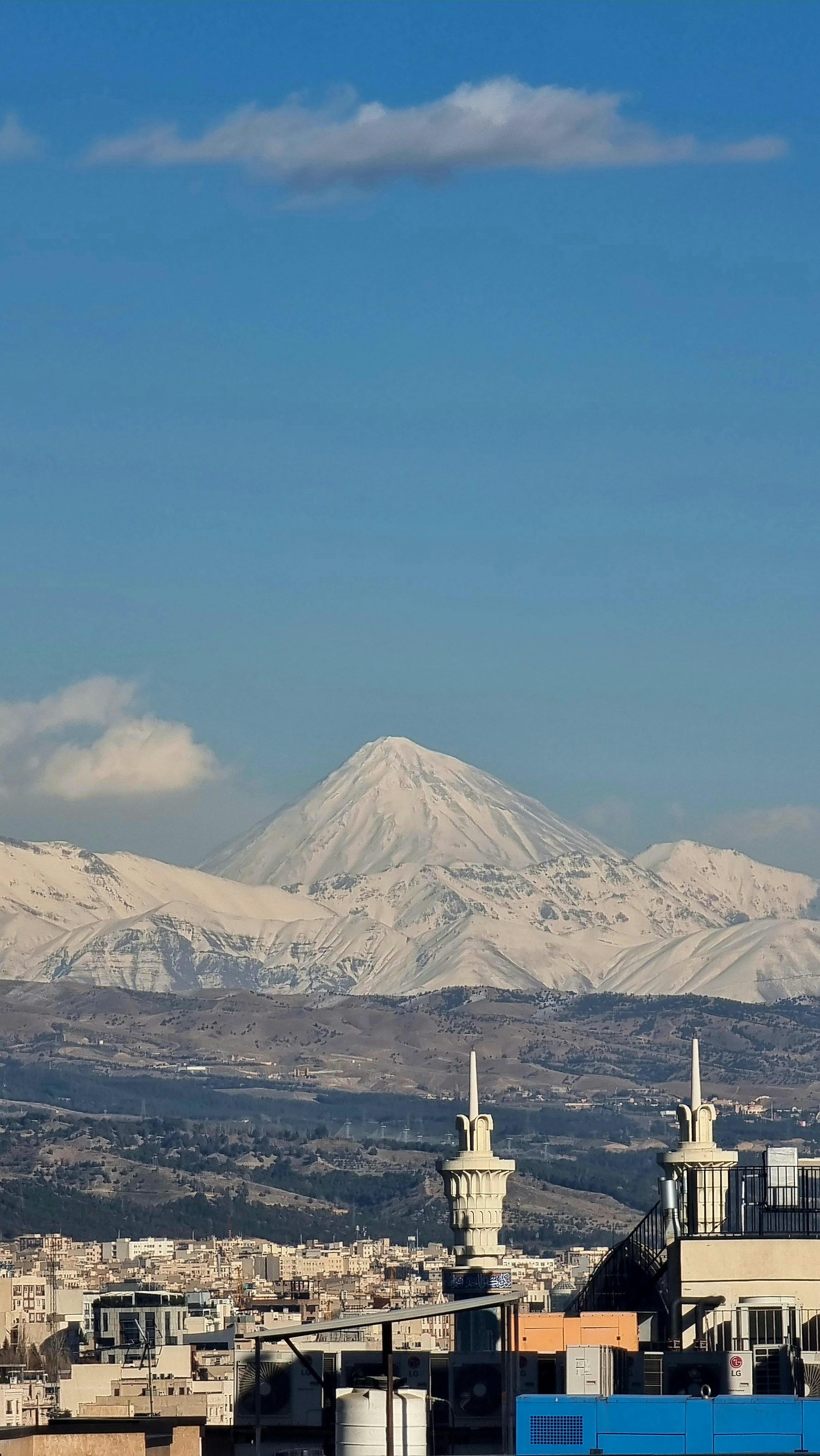 Snow-Capped Peak Over a Modern Skyline