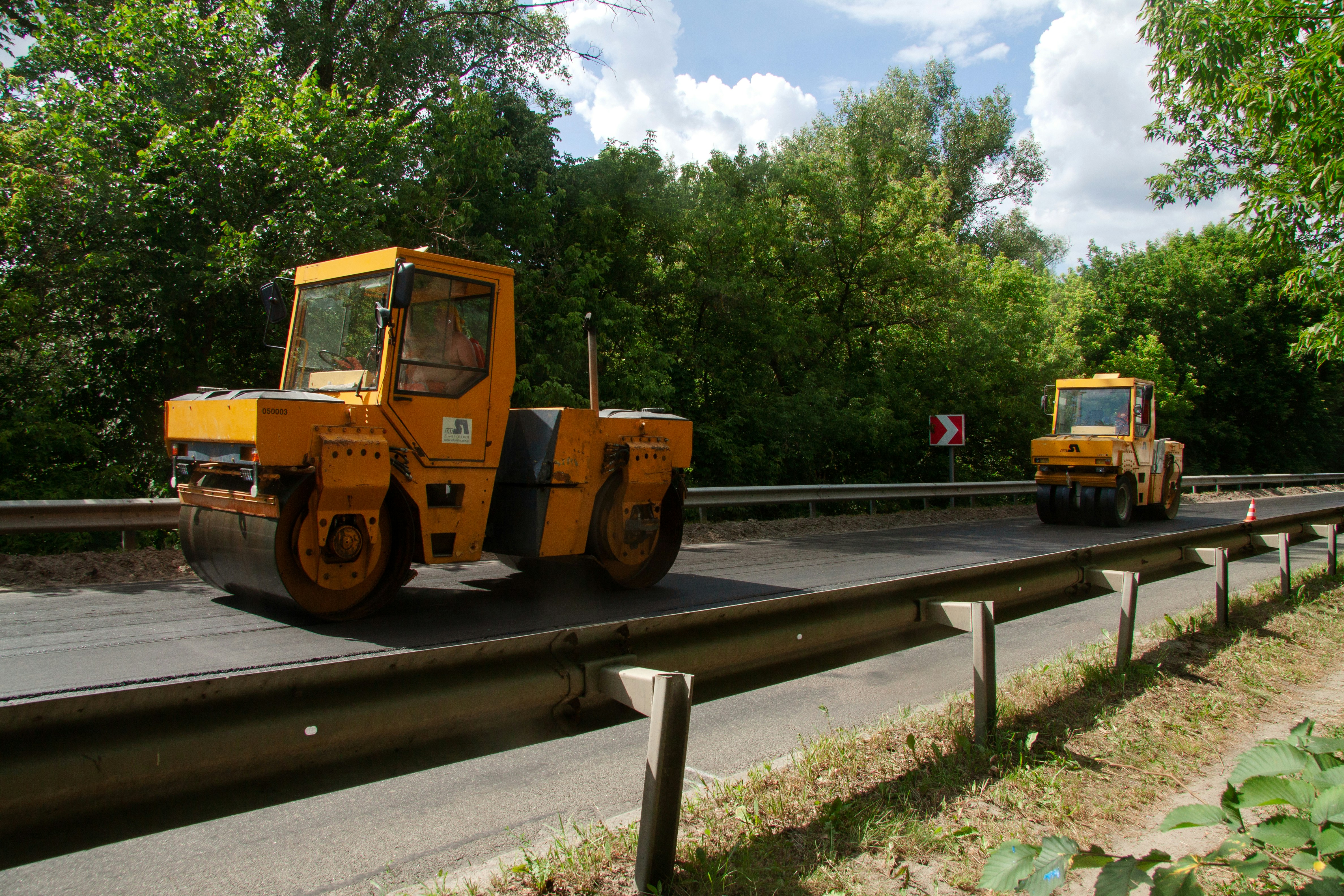 Two Road Rollers Drift Along a Quiet Highway