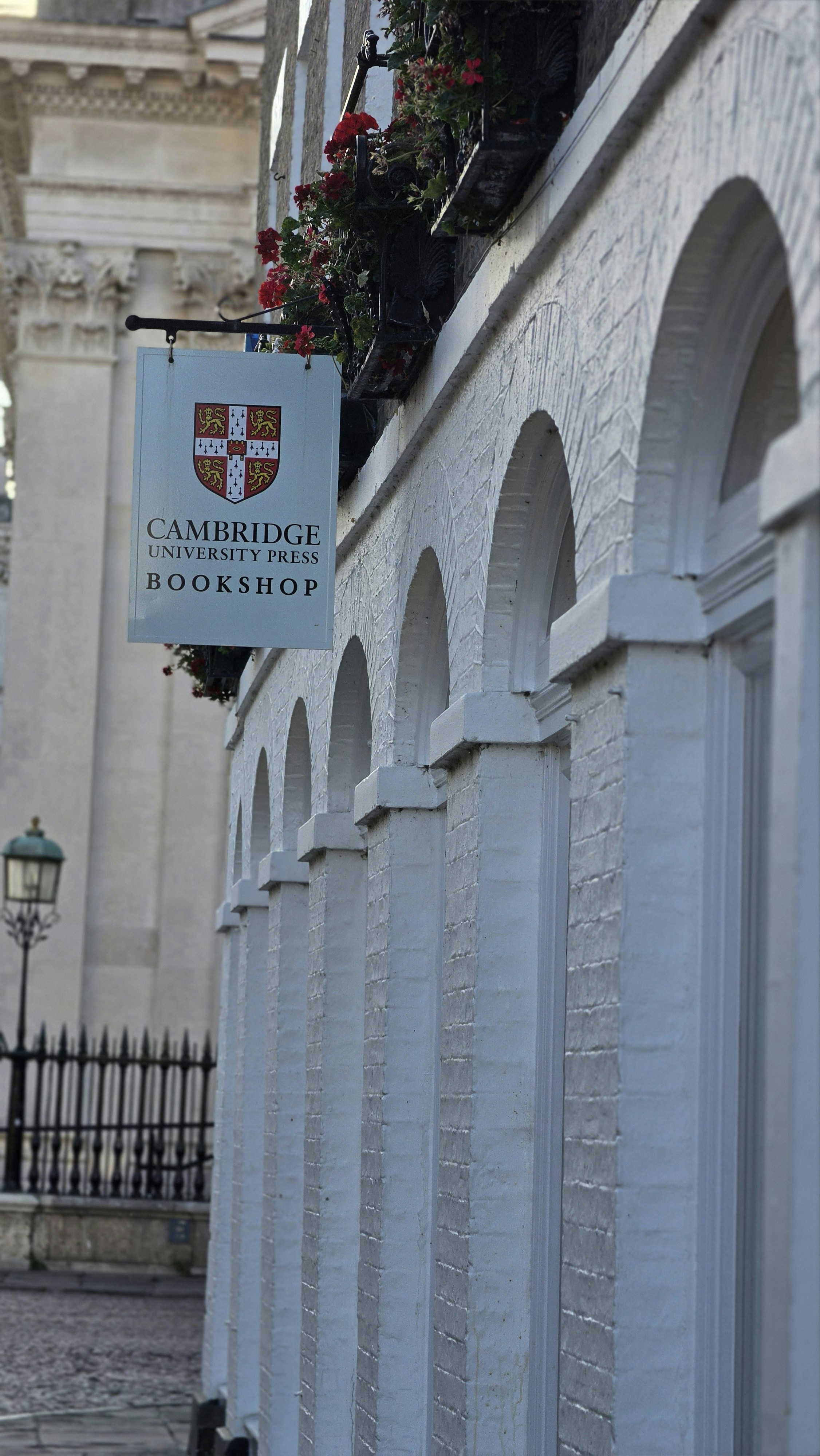 Hang of Books: A Cambridge Bookshop Sign Against Arched White Facade