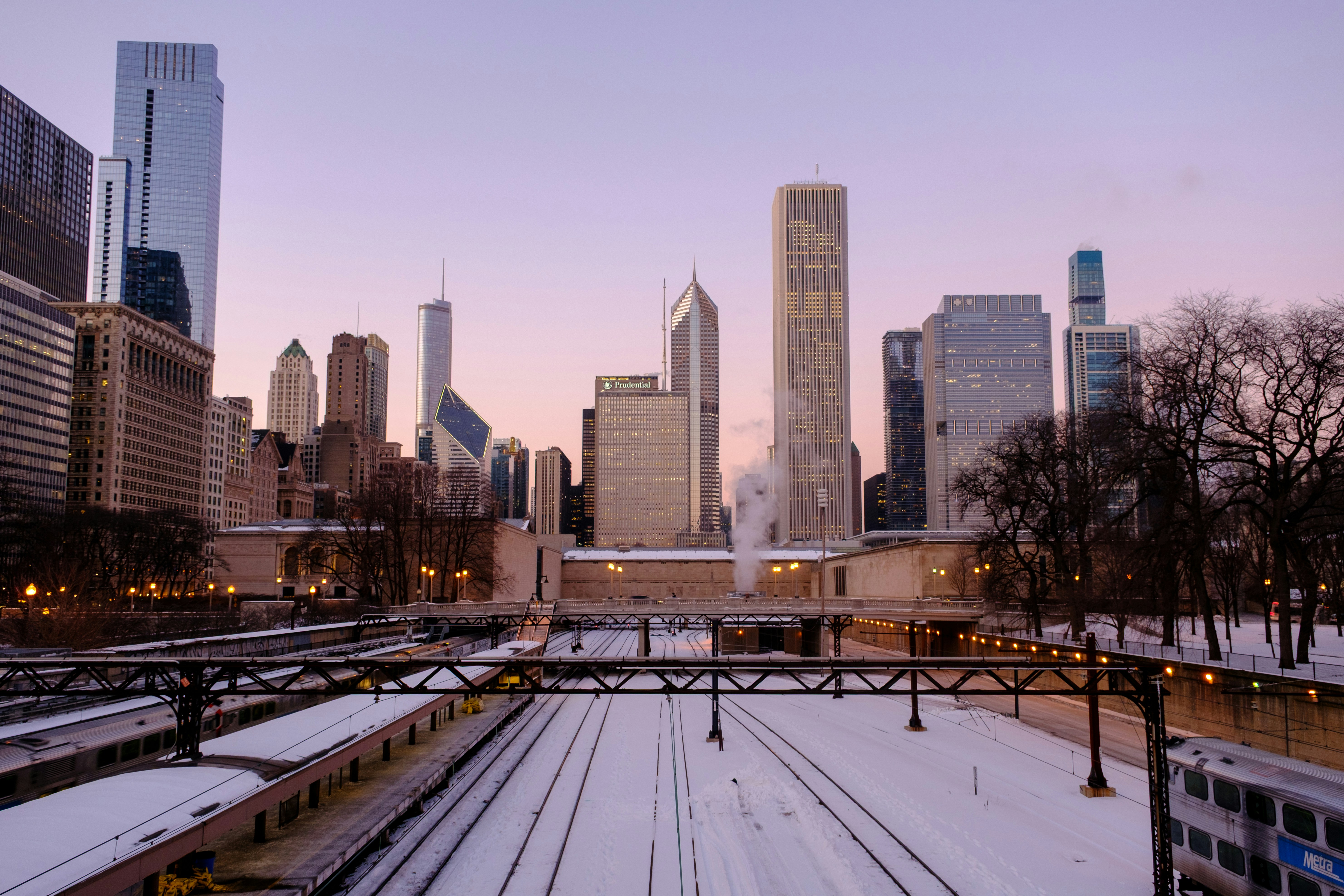 Winter Dawn Over the Skyline: Snowy Riverwalk Bollards and Timeless Towers