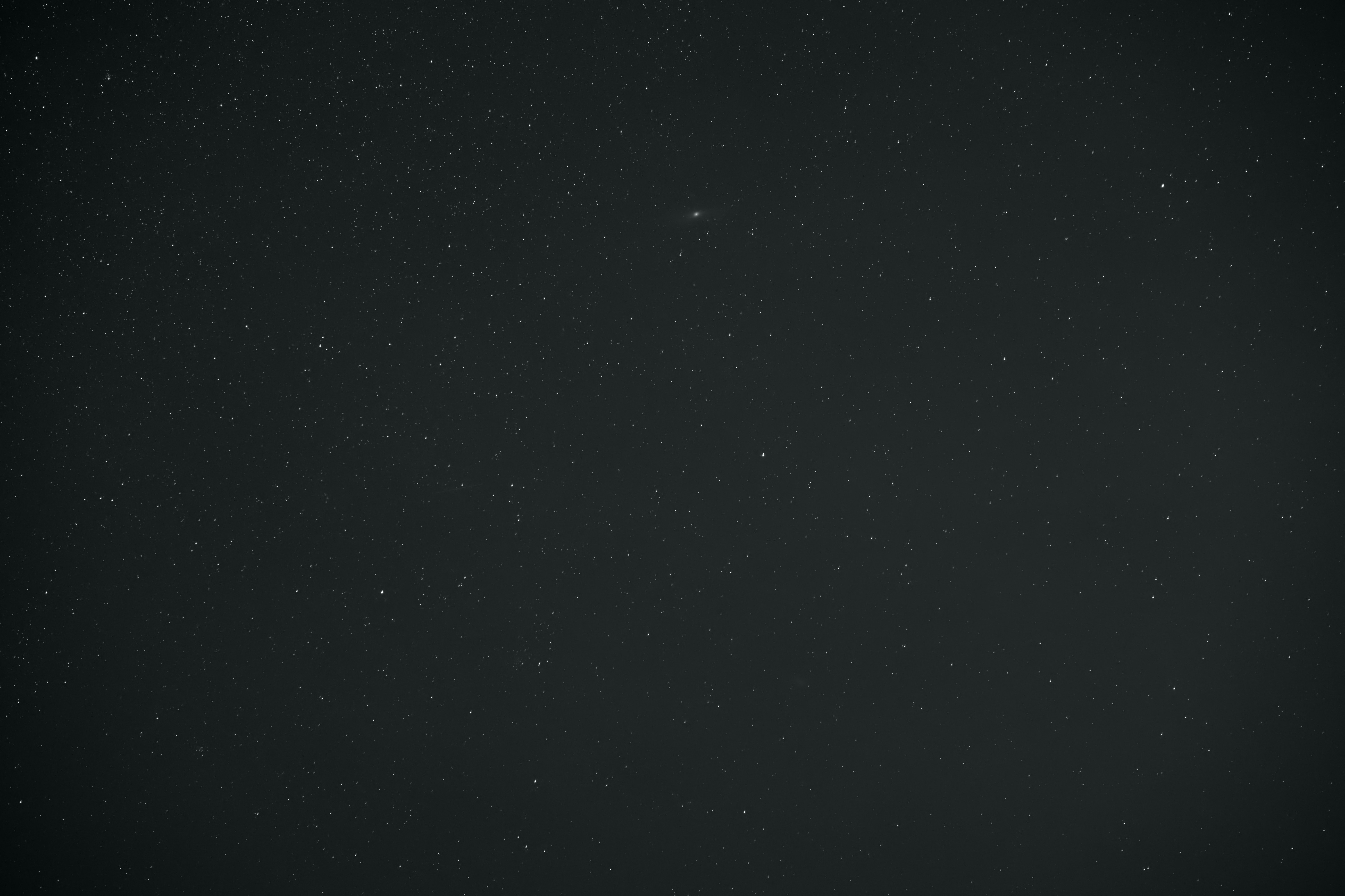 Starry night sky filled with countless points of light, rendered in grayscale for a calm celestial panorama.