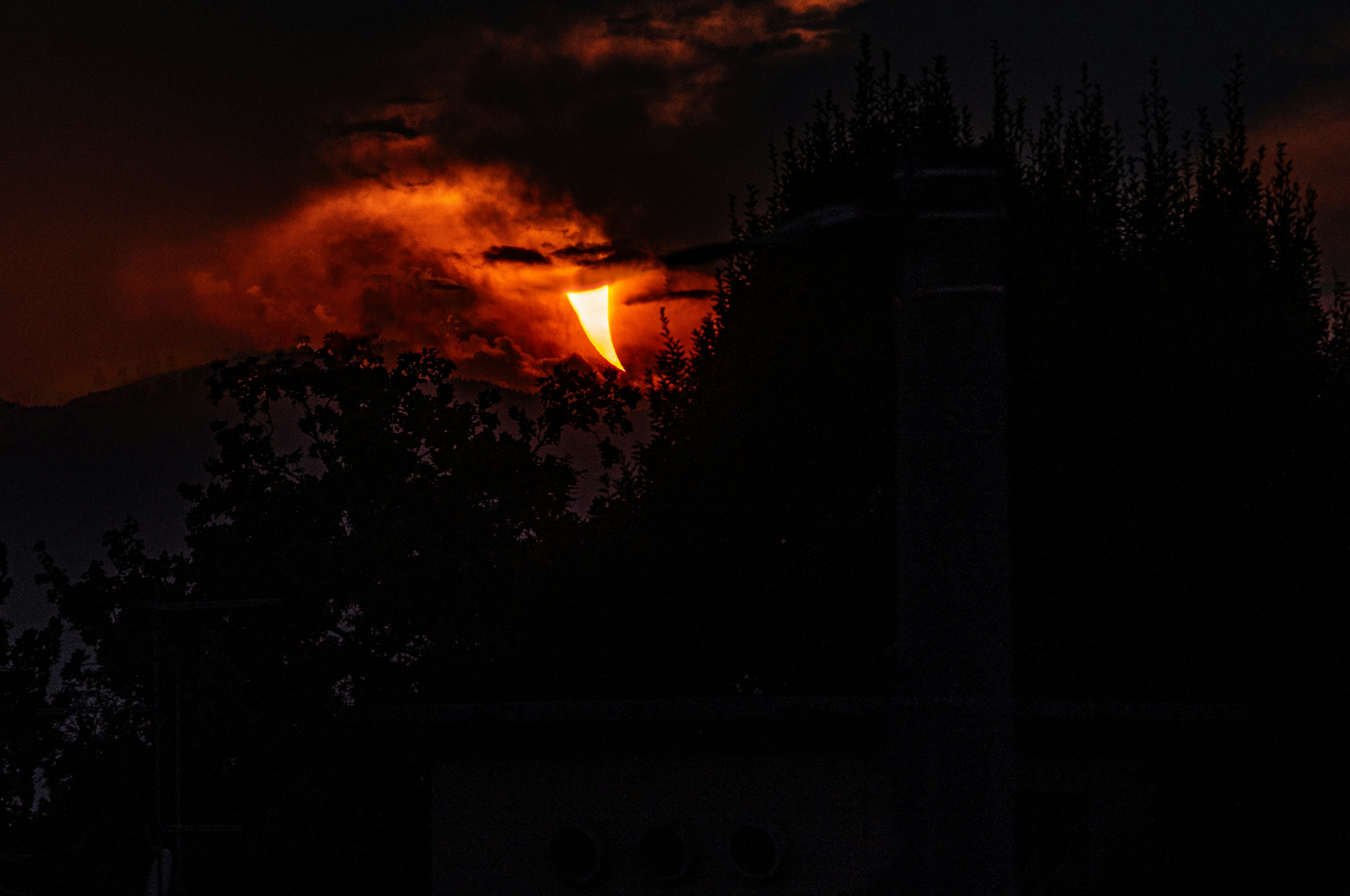Crimson Crescent Behind Silent Rooftops