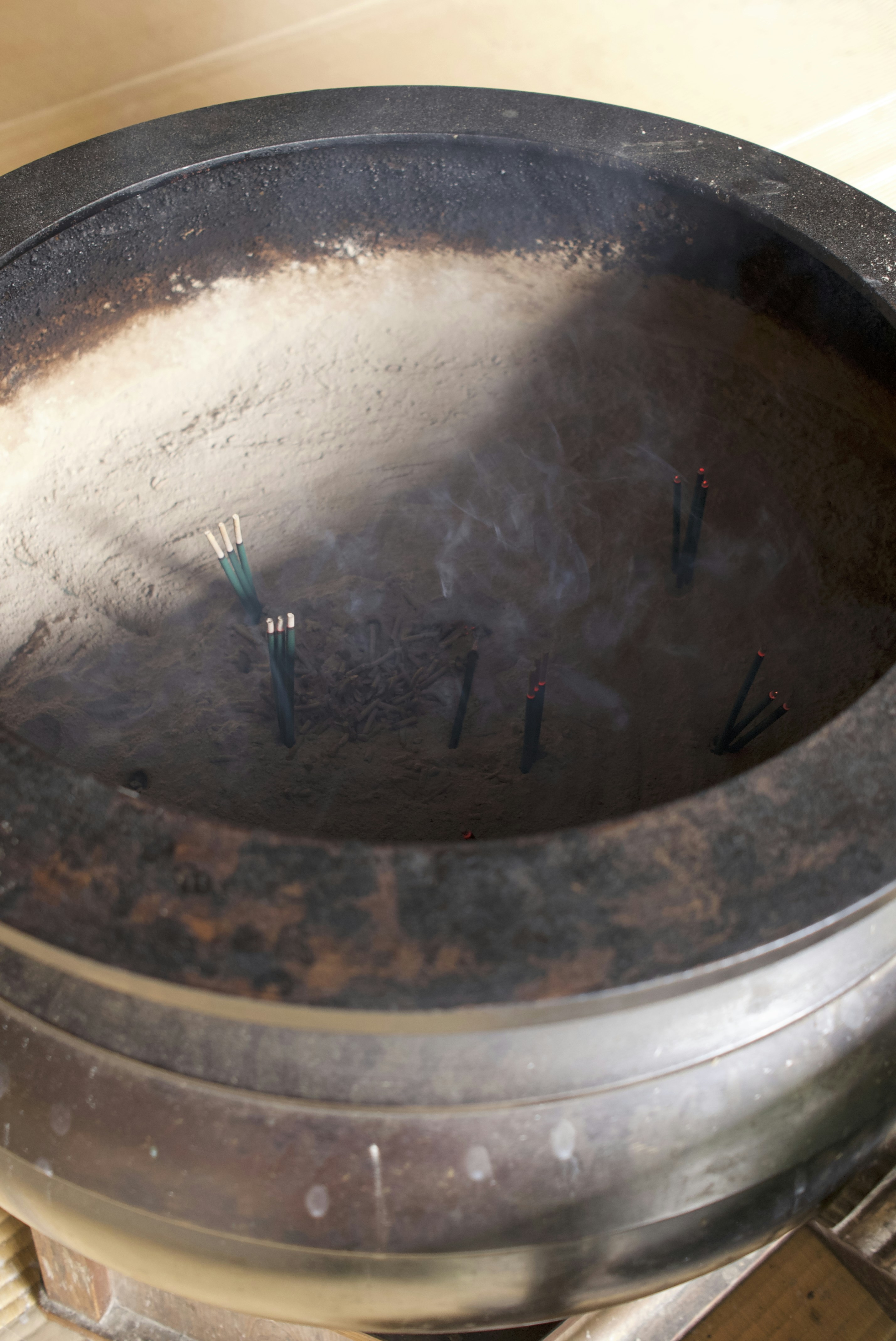 Smoldering incense bowl: quiet steam in a rustic metal cauldron