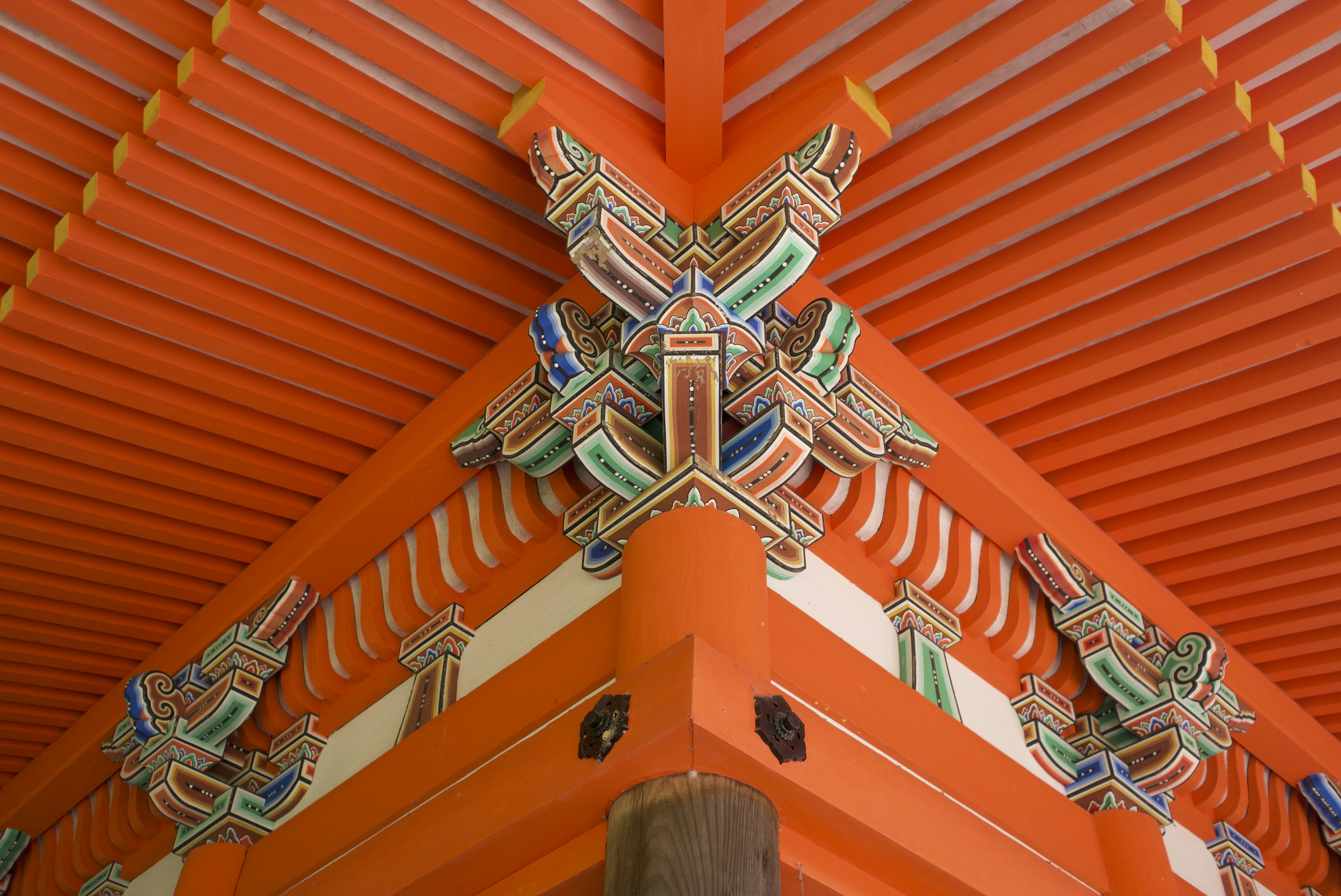 Ornate Temple Friezes Beneath a Crimson Eave