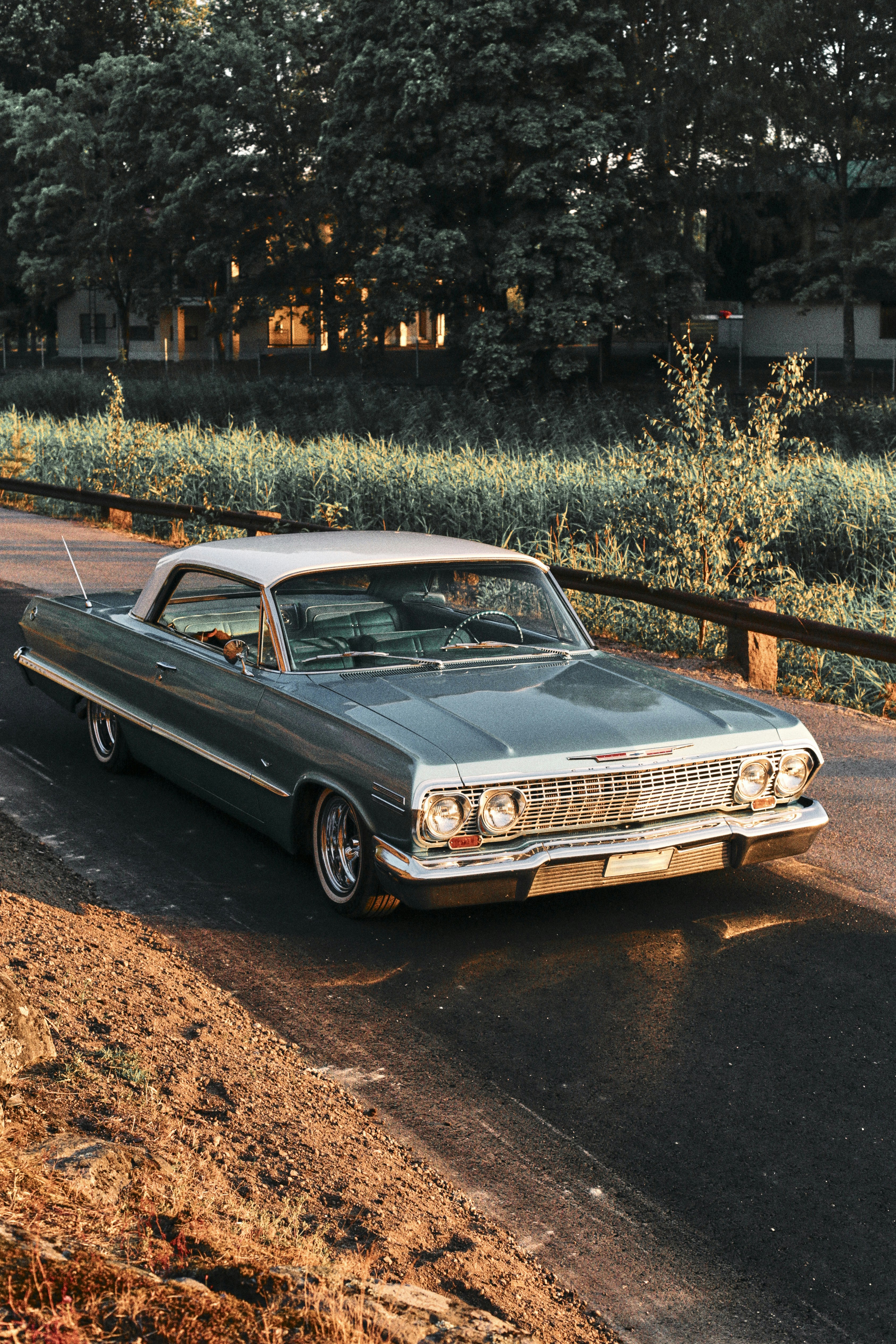 Sunlit Classic: A vintage Chevrolet rests on a quiet roadside
