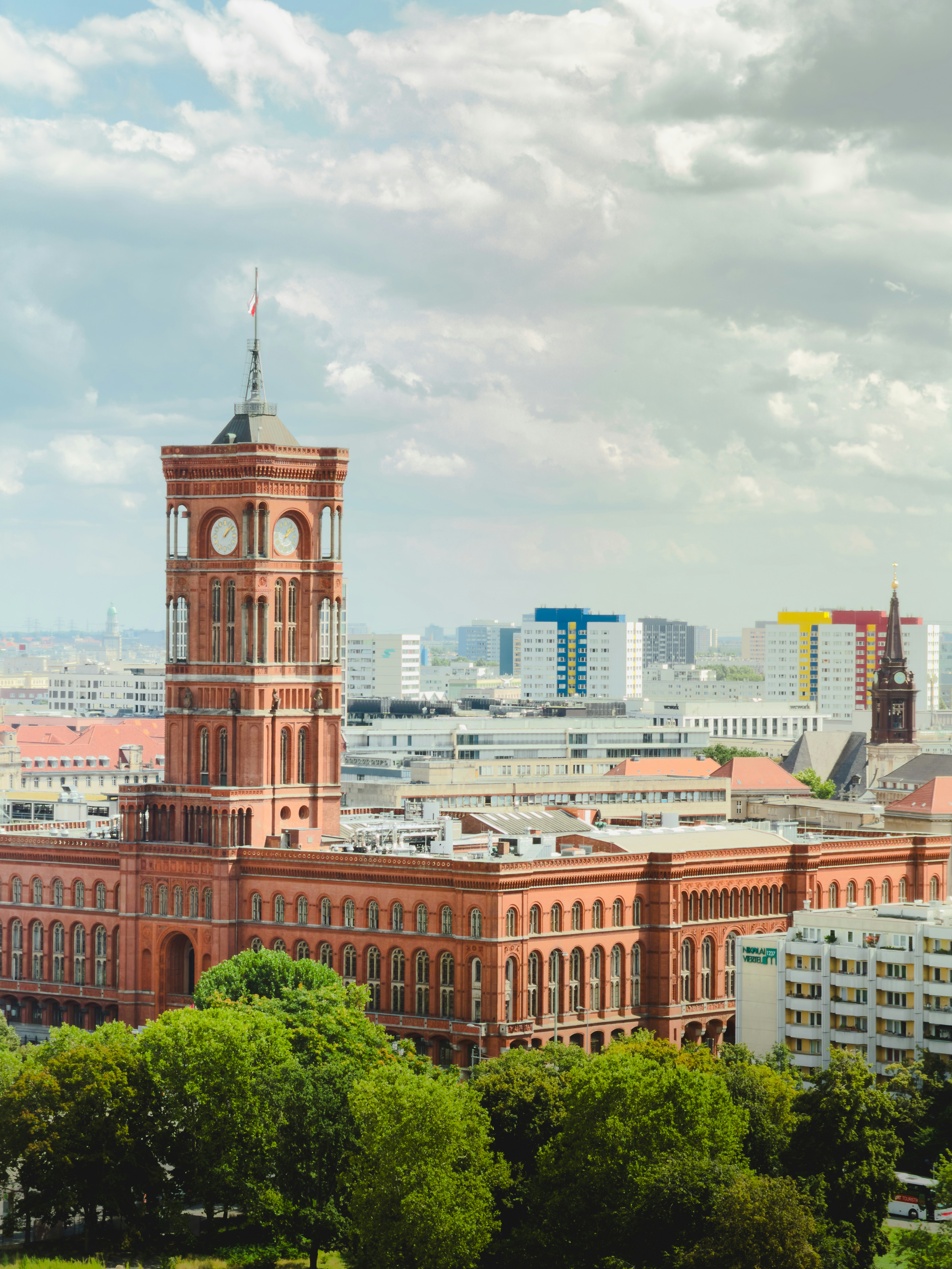 Red Brick Clock Tower Rising Above a Green Canopy