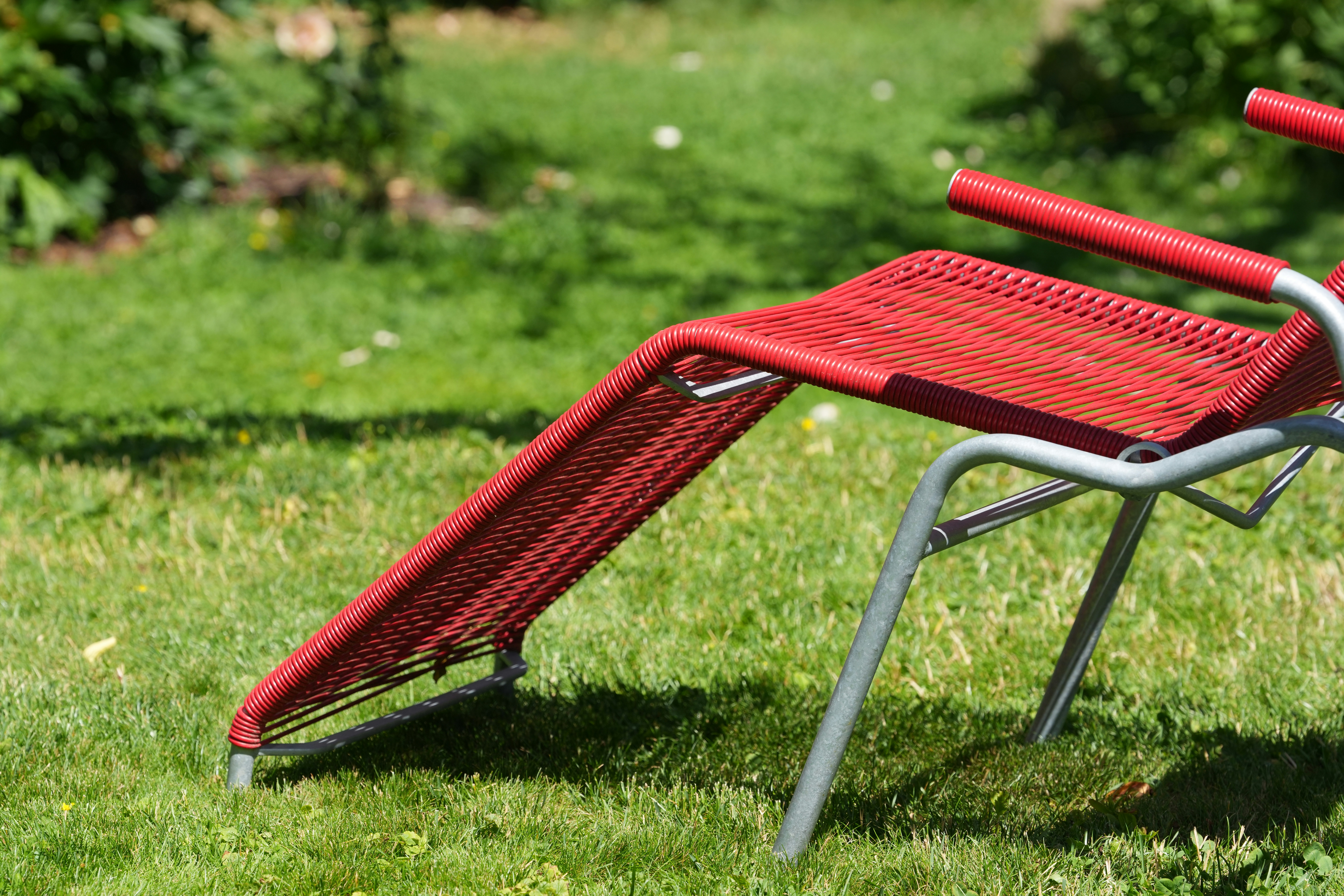 Red Garden Chair Sloped Across the Lawn