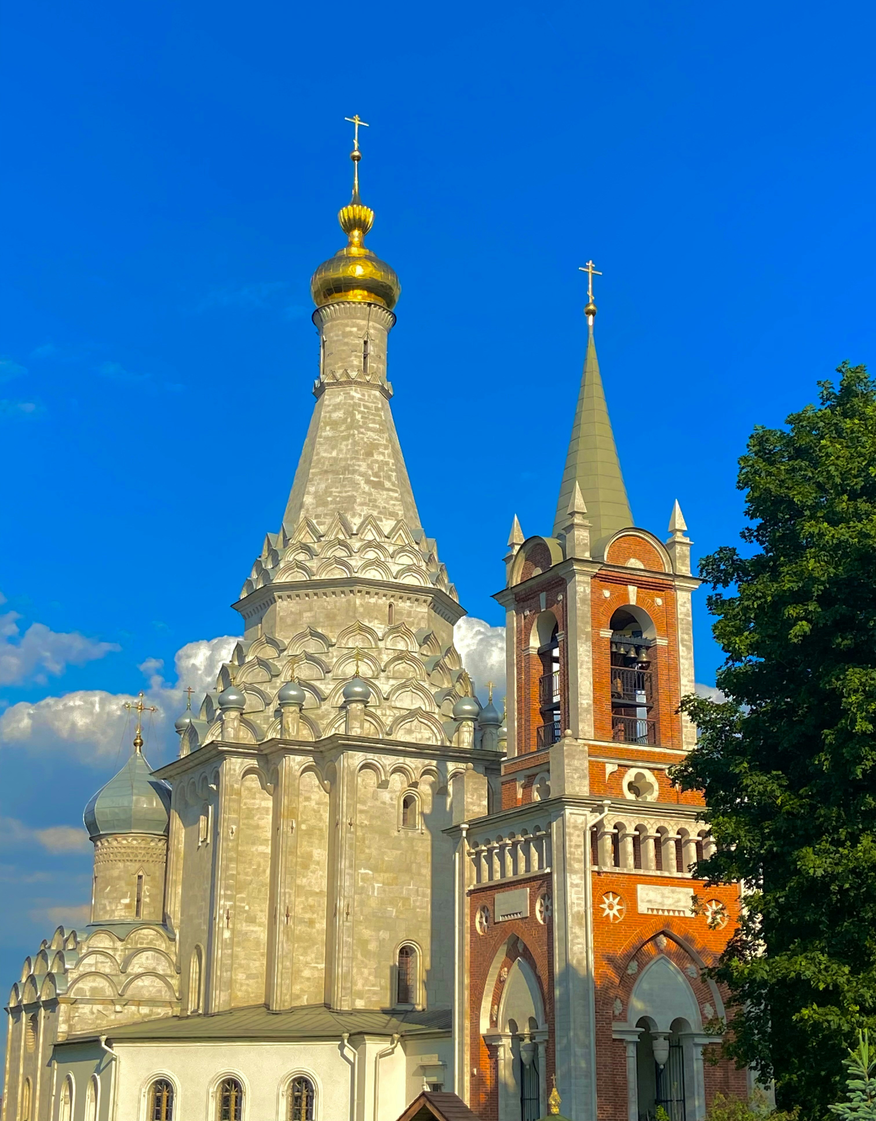 Golden Dome and Brick Bell Tower Rising Above a Blue Sky