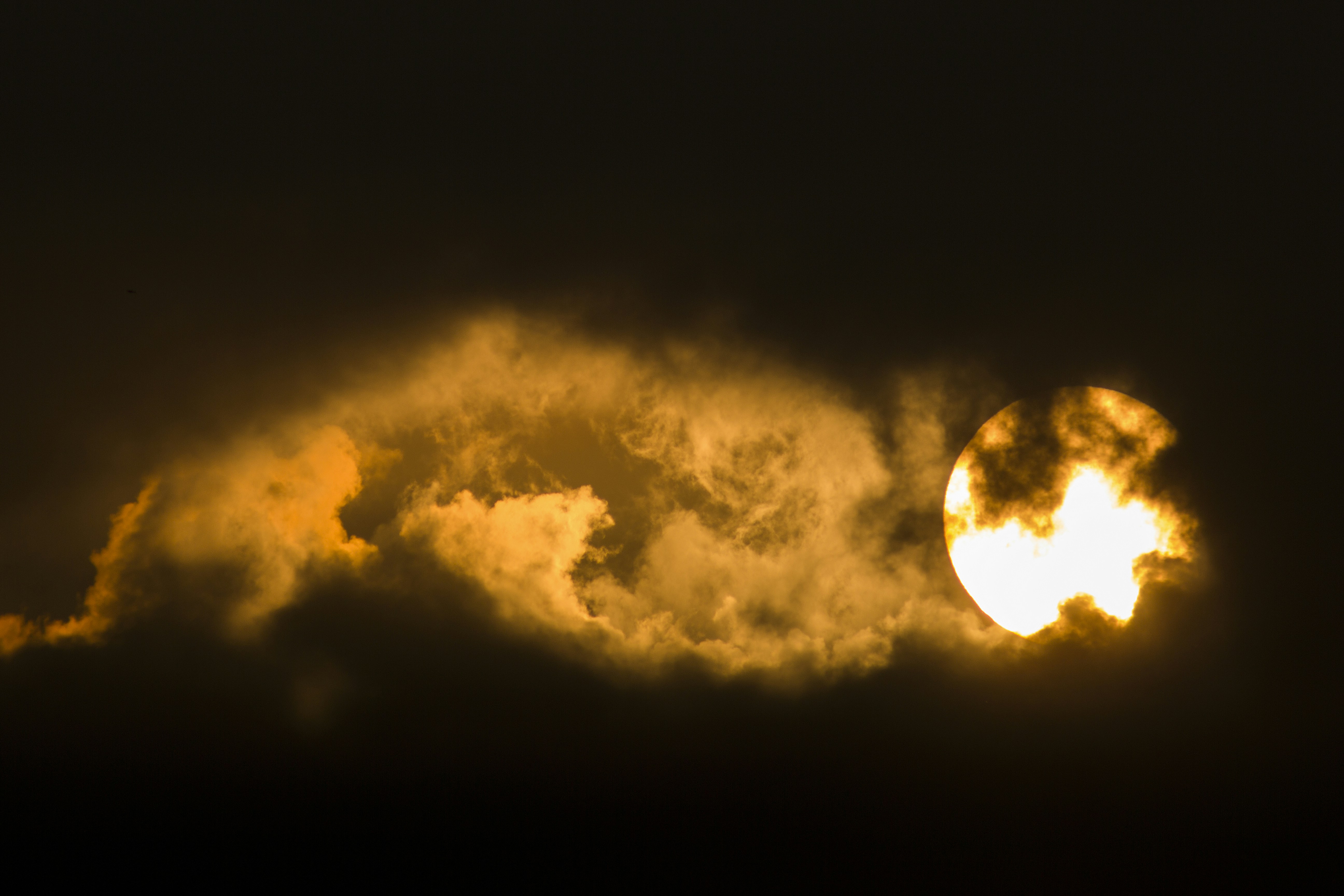 Sunlit cloud crescent: a fiery break through the dusk