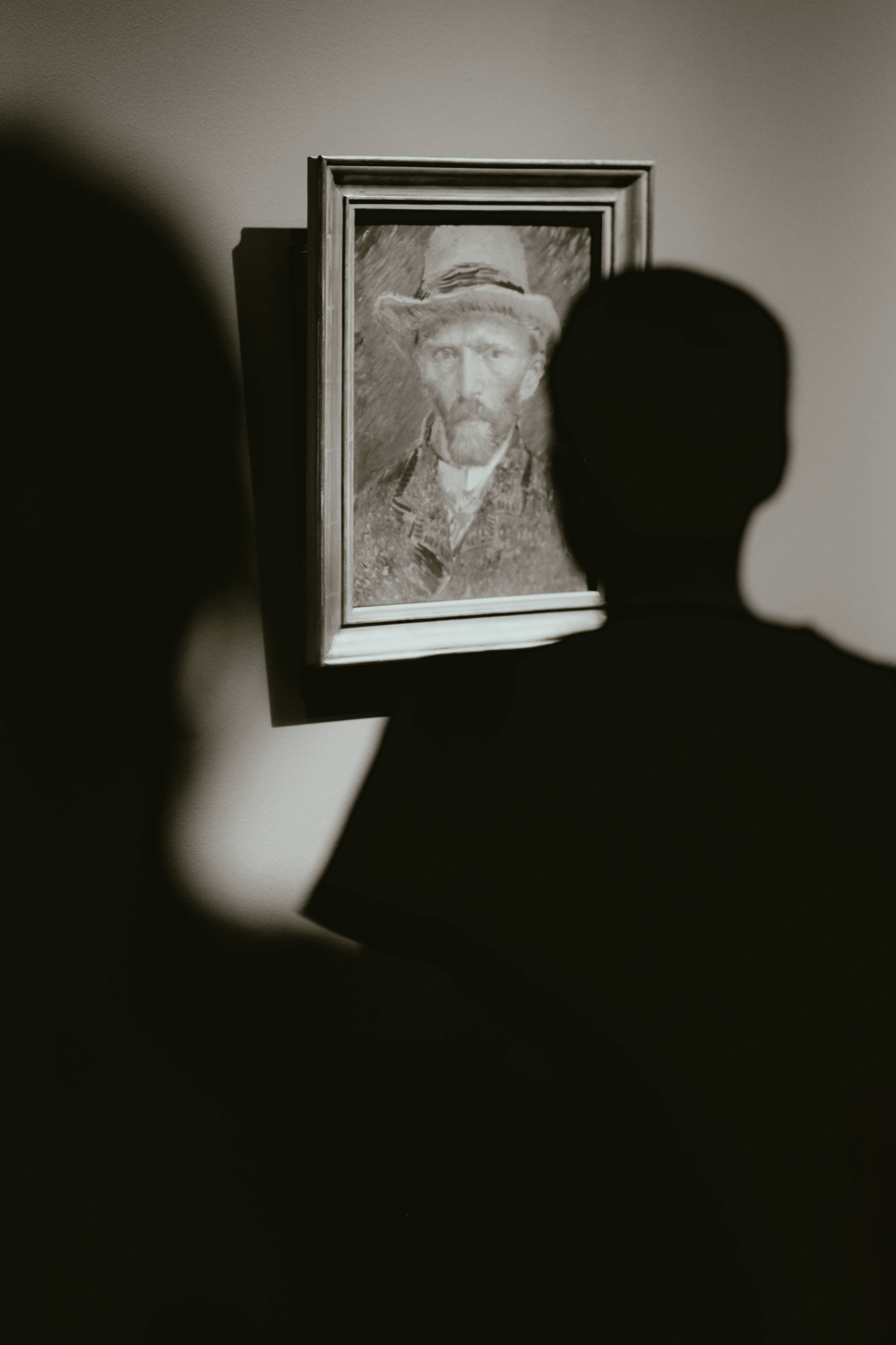 Shadowed Portrait: A Curious Viewer Stares at a Framed Gentleman