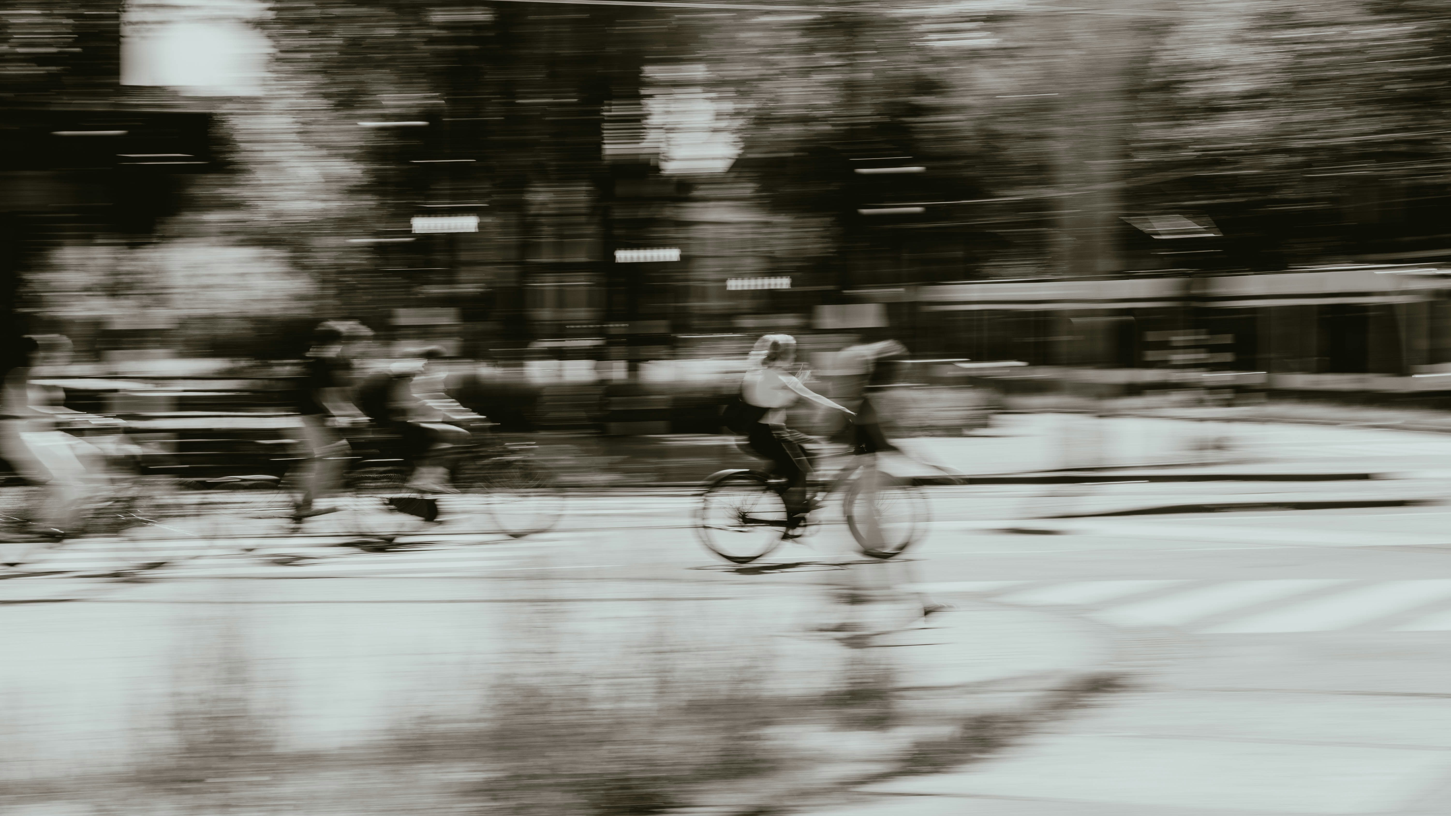 Motion in Mono: Cyclists Blur Through a Quiet Park