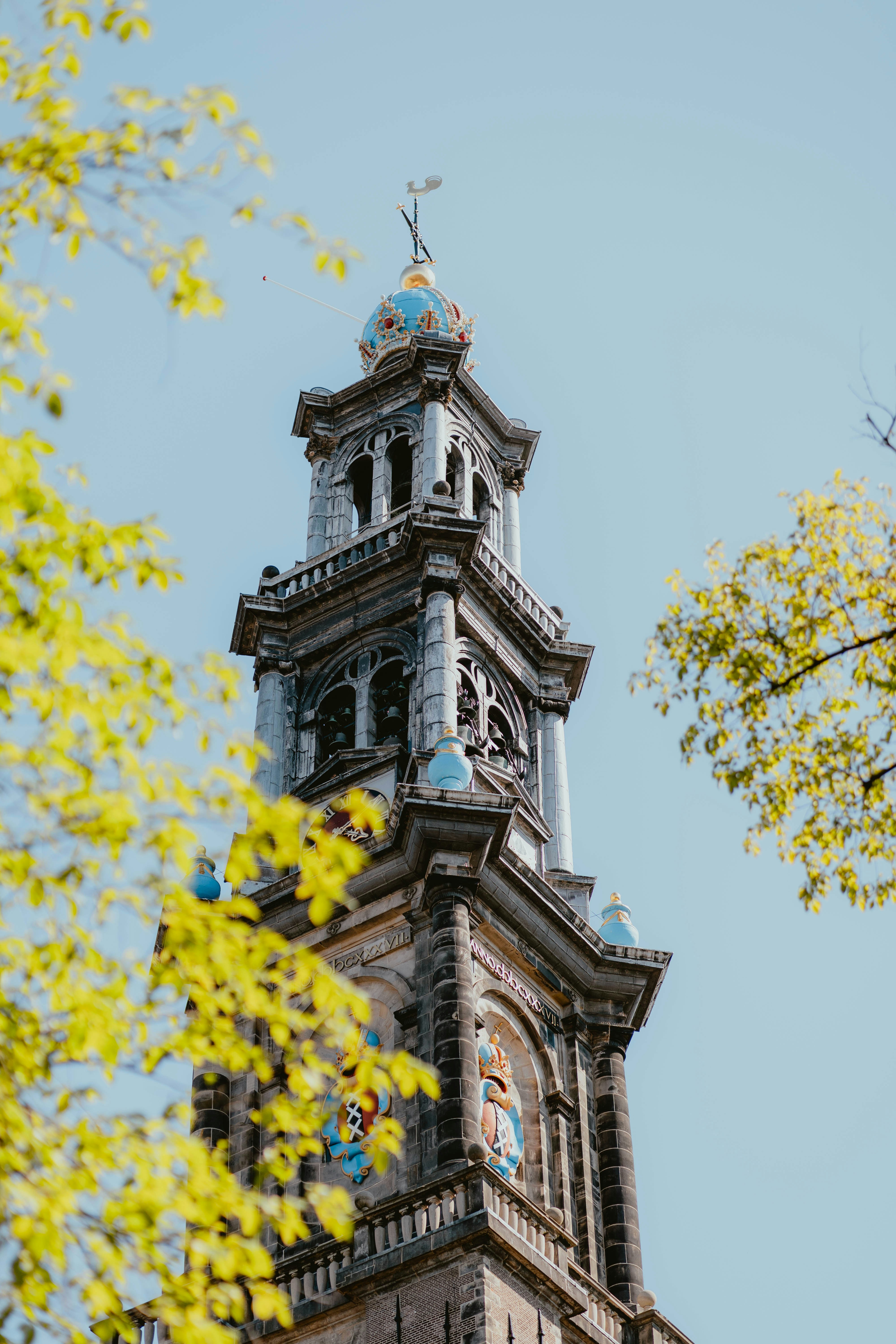 Towering Clockwork: A Weathered Steeple Rises Through Spring Light
