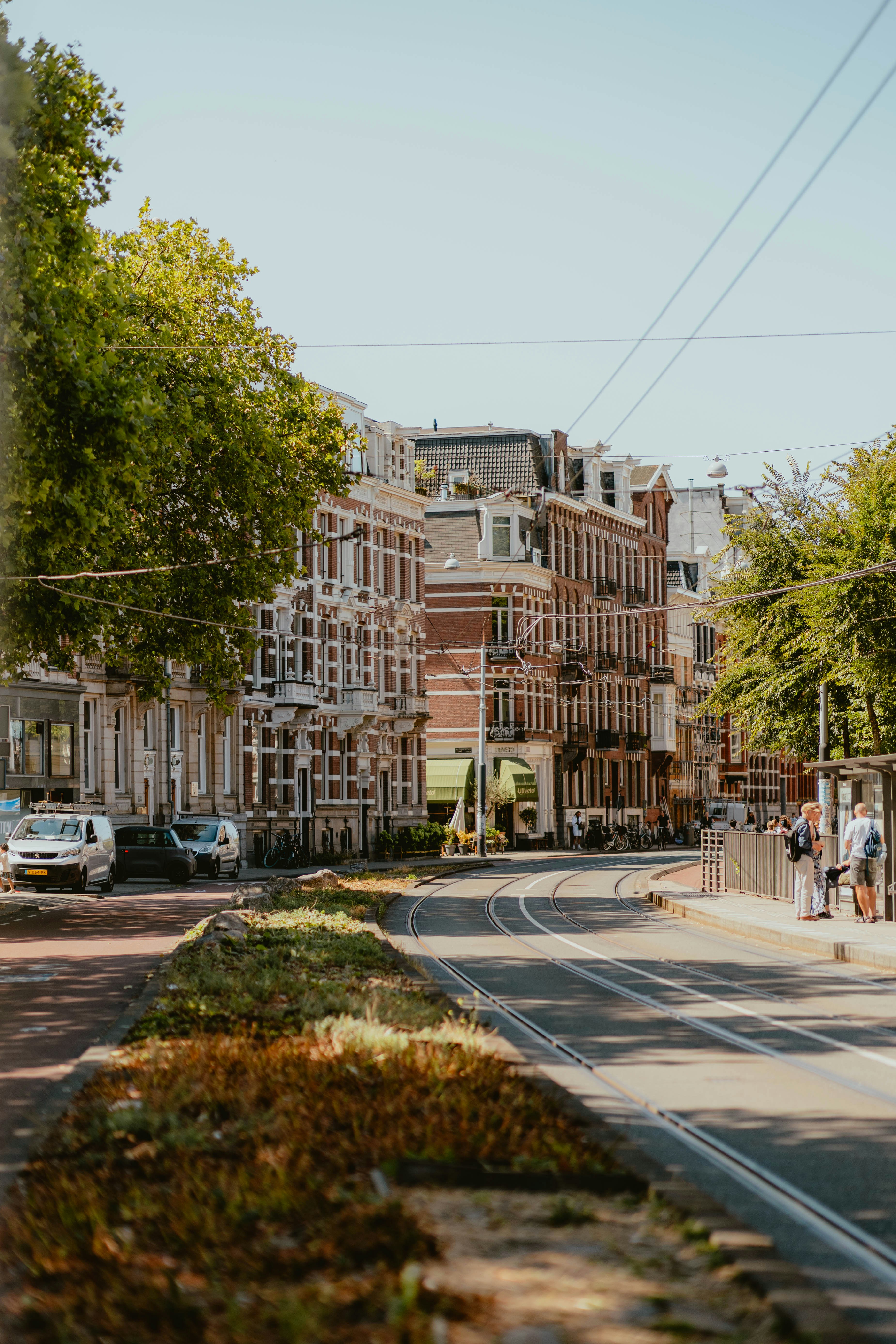 Urban Tramline Bend: Sunlit Rows of Brick Facades
