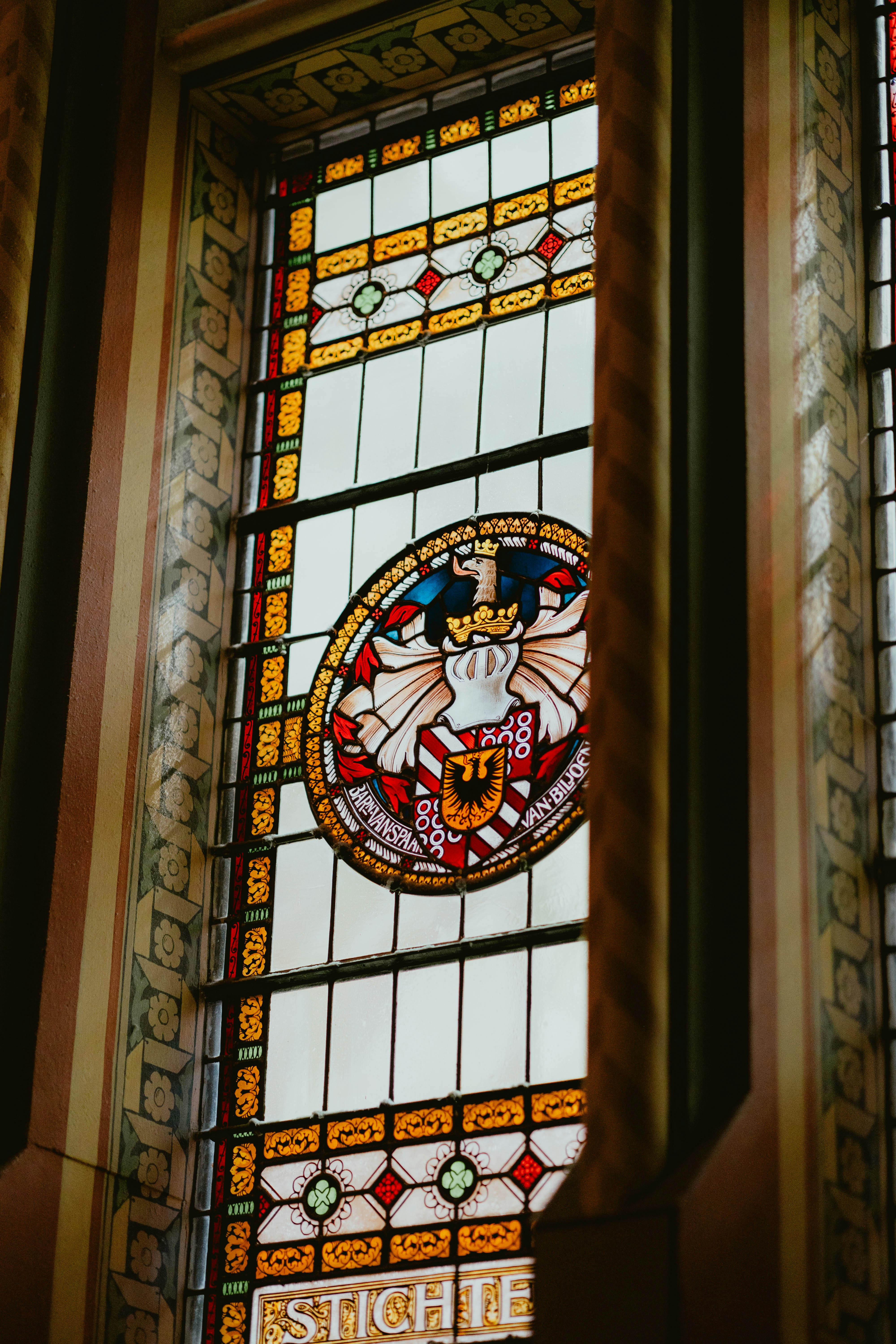Stained Glass Insignia: Archway, Crest, and Ornament in Warm Light