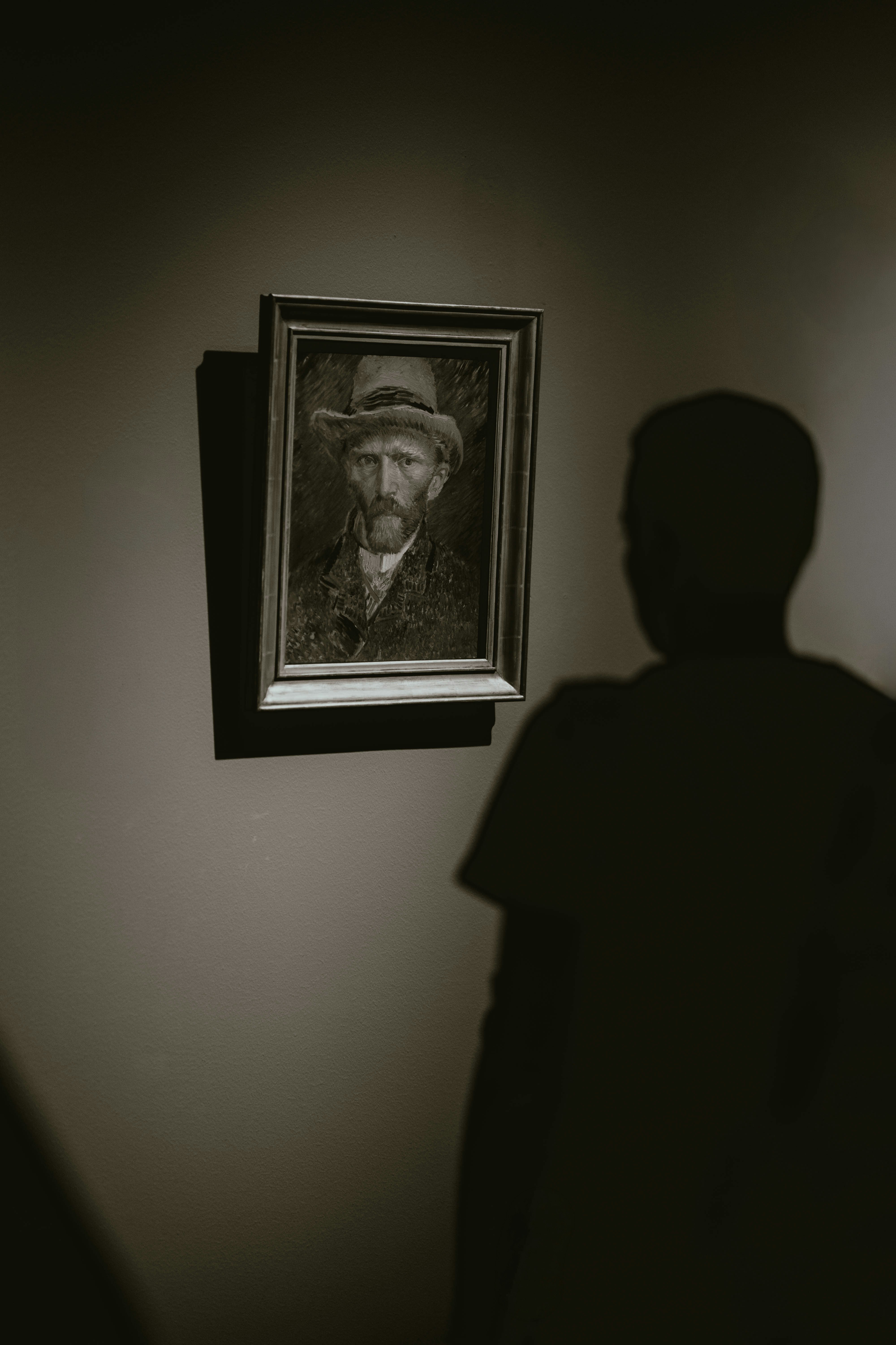 Shadowed Portrait: A Visitor before a Framed Master