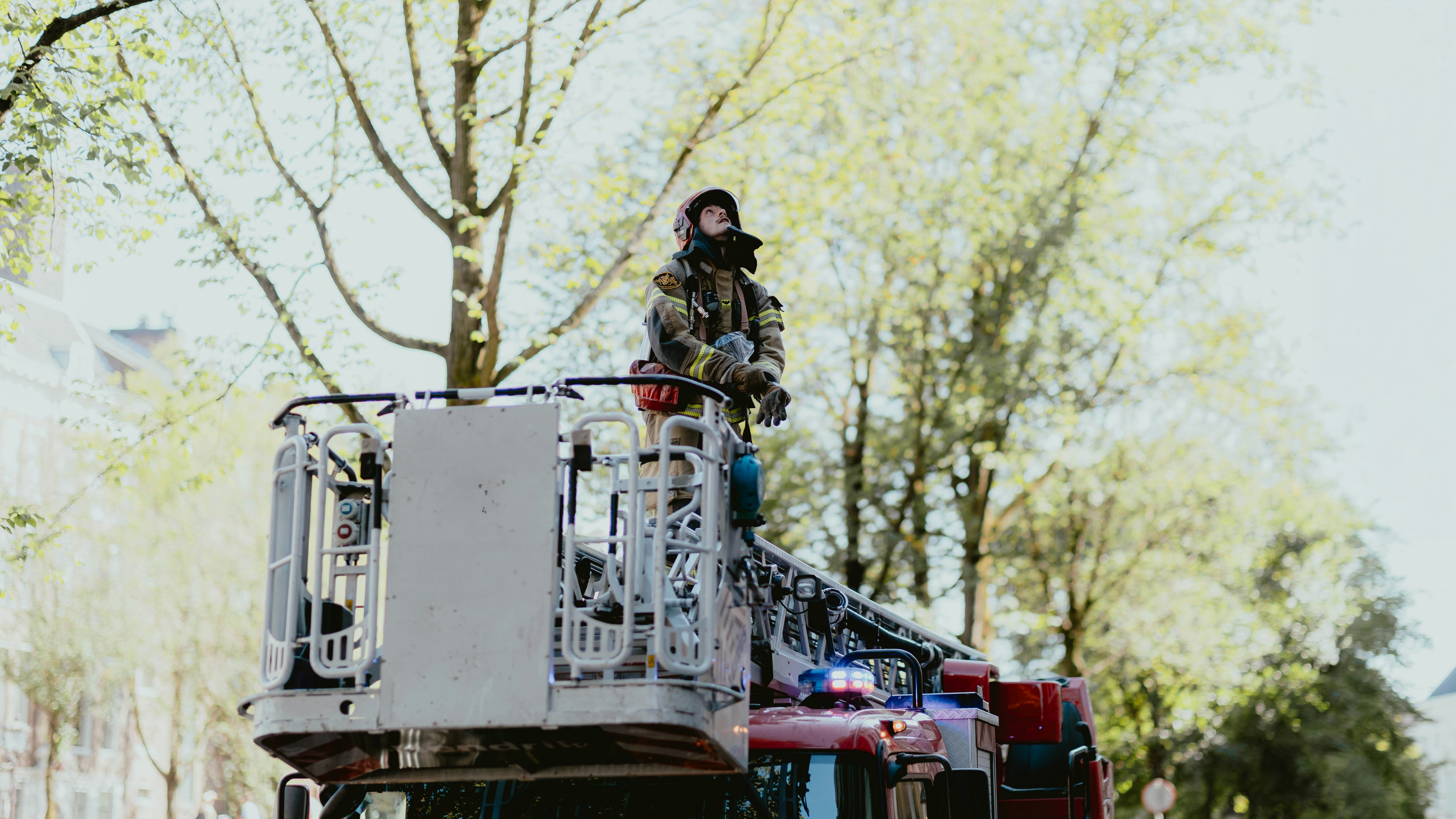 Firefighter Sentinel on the Lift: A Quiet Moment Above the Street