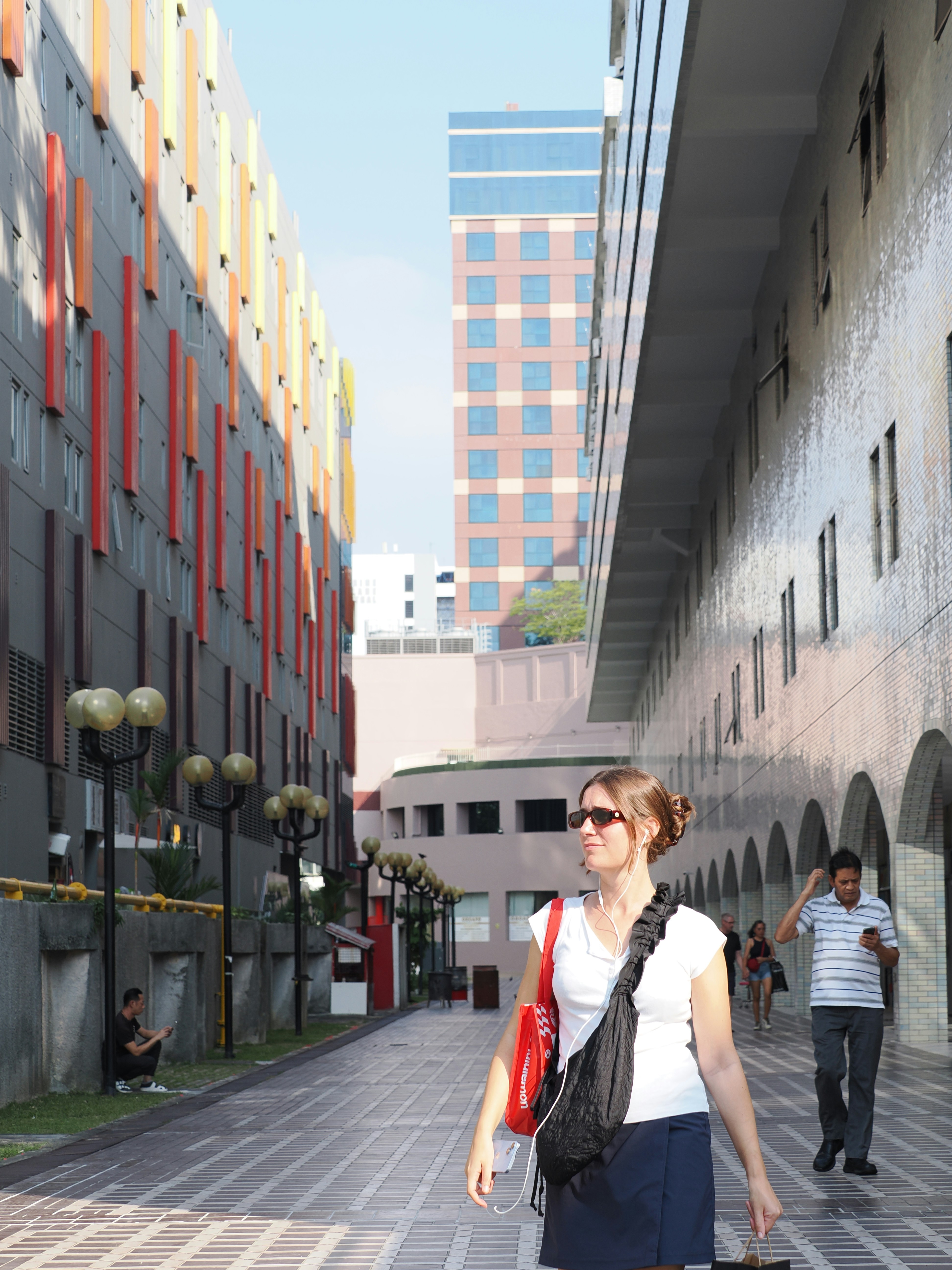 Urban Walk: A Woman Pauses Amid Colorful Facades
