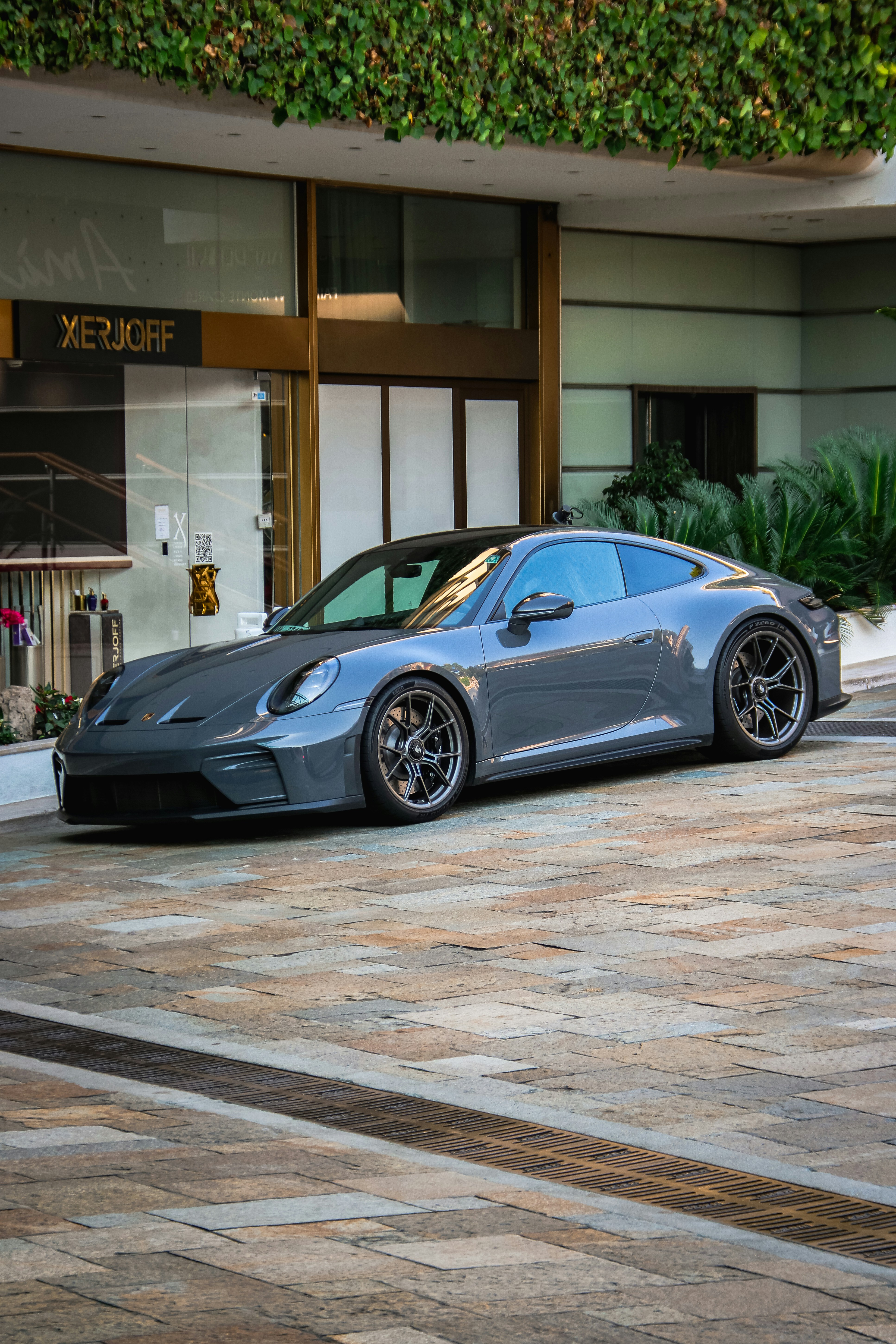 Grey Precision: A Porsche Resting Before a Luxe Entrance
