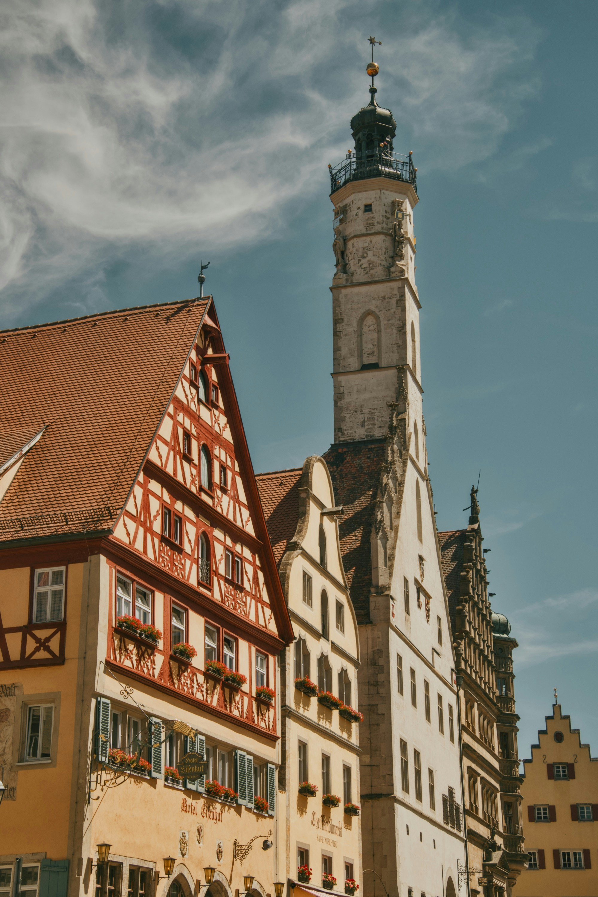 Historic Row: Sunlit Fachwerk and Tower Amid Blue Skies