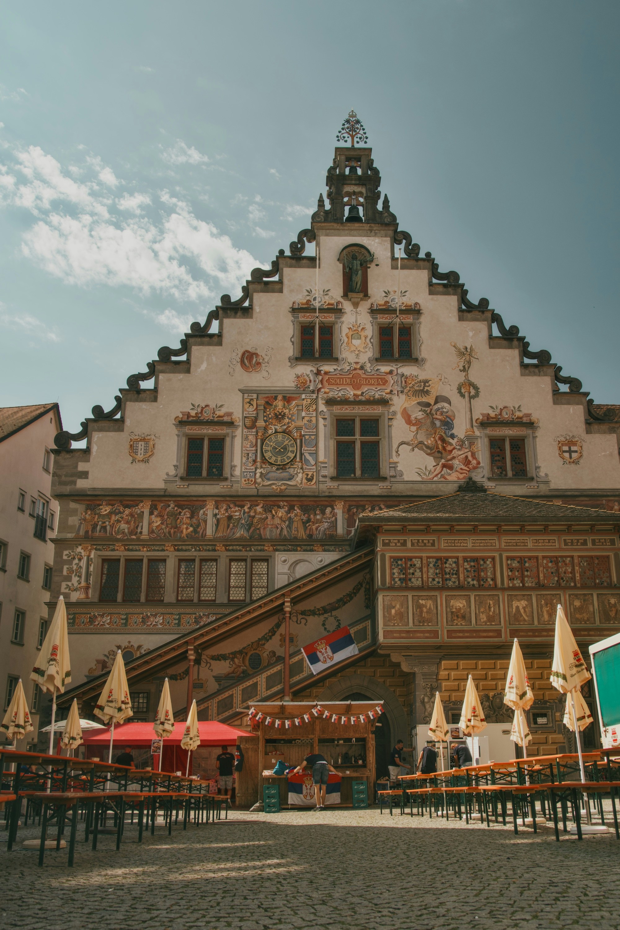 The historic town hall in Lindau with painted murals and a Serbian flag