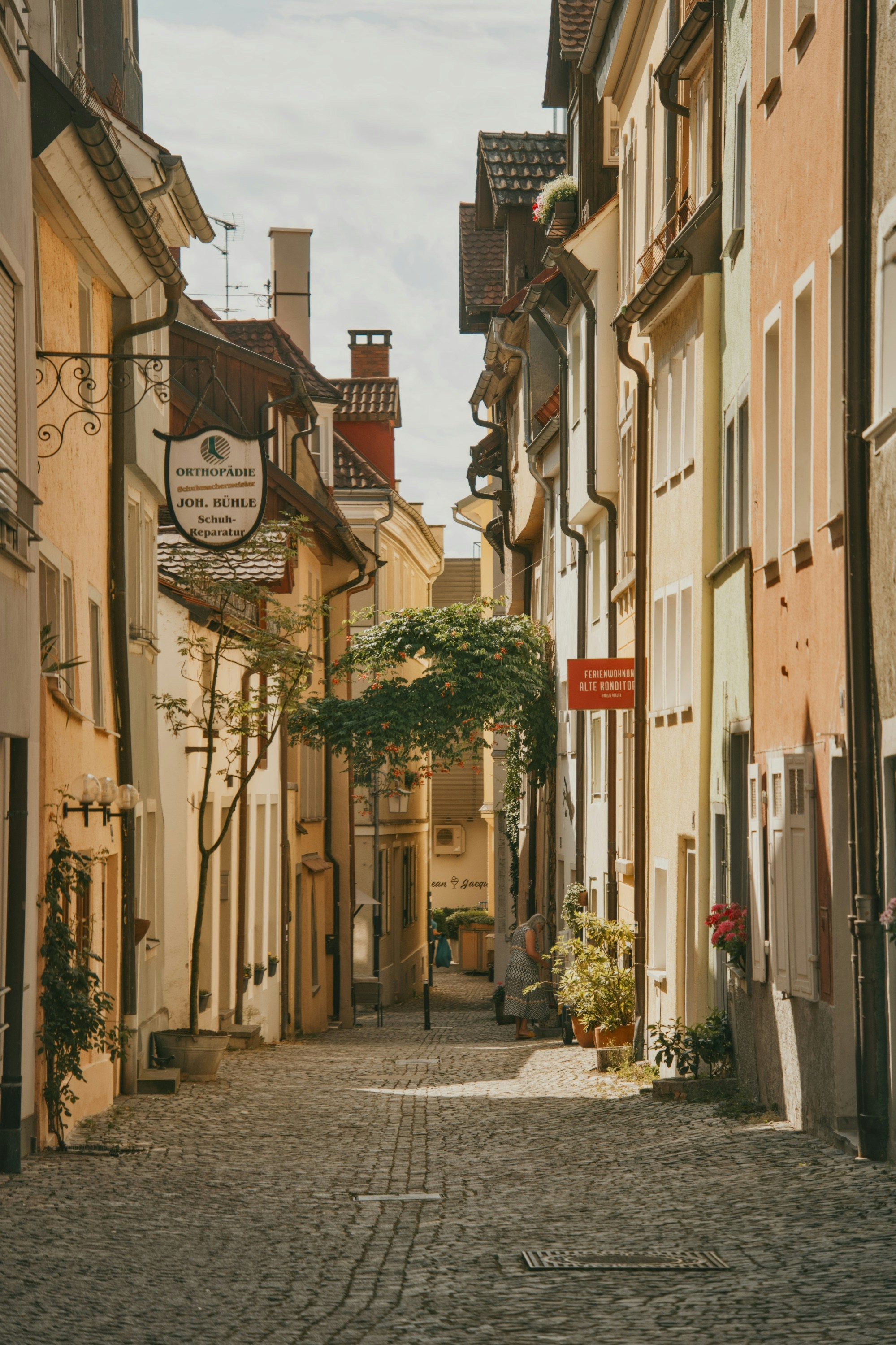 Cobbled Quiet: Sunlit Street Through a Classical European Alley